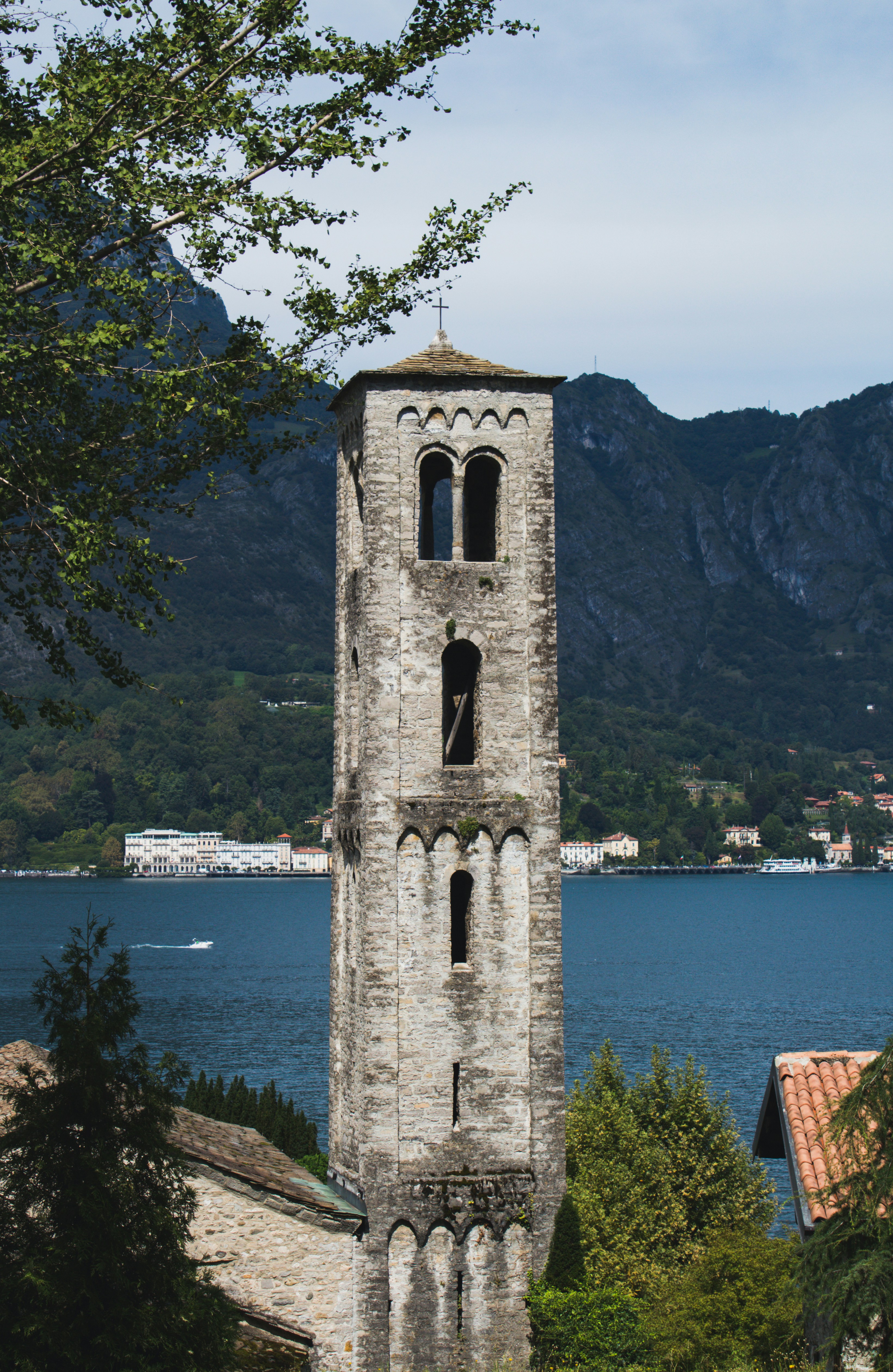 Stone Bell Tower Framed by Lake and Alpine Backdrop