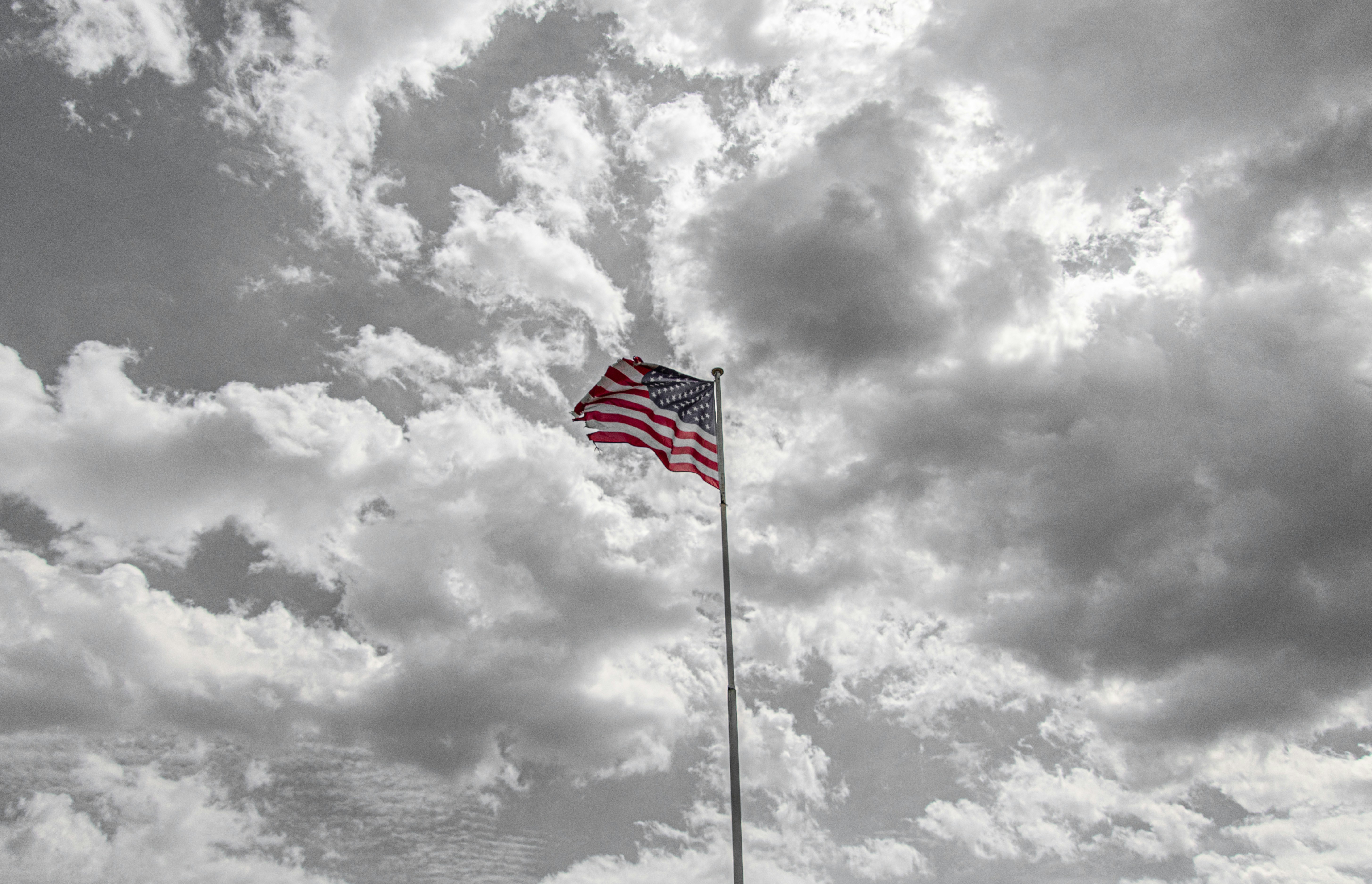 Flag Against the Cloudscape: A Lone Emblem Rising Over the Sky