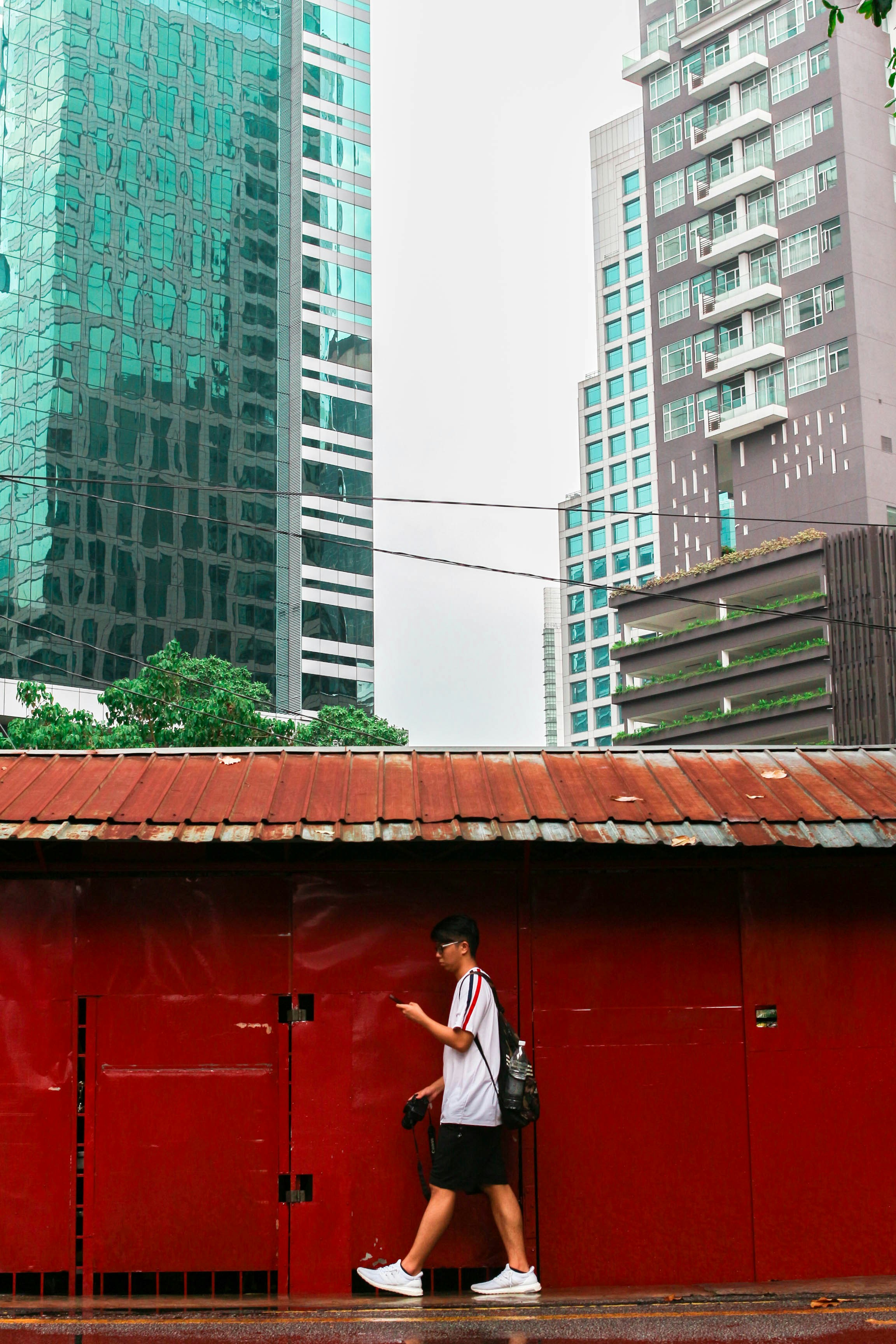 Man walking beside red building during daytime photo – Free Human Image ...