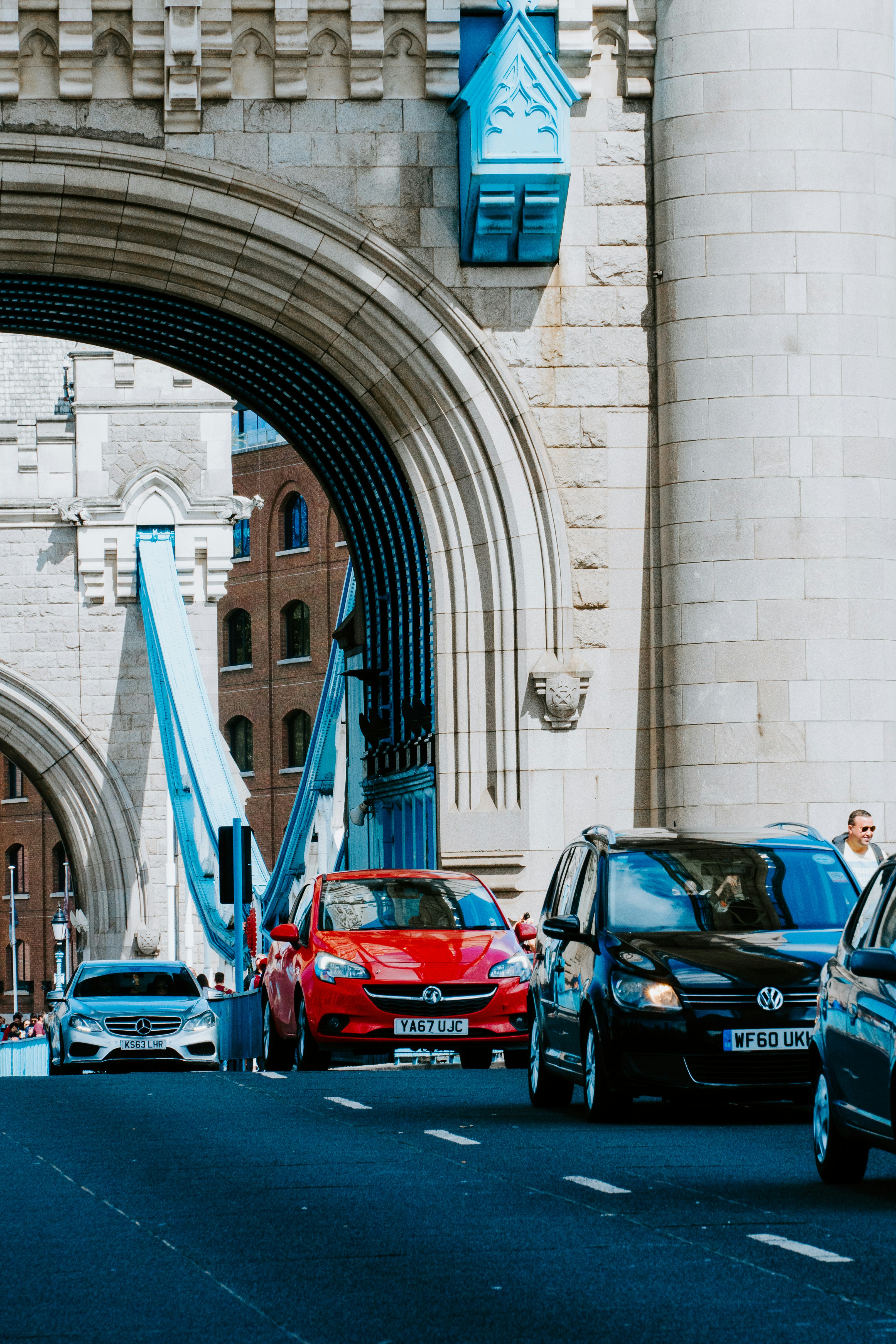 Blue-accented arch with a trio of cars at London’s Tower Bridge approach