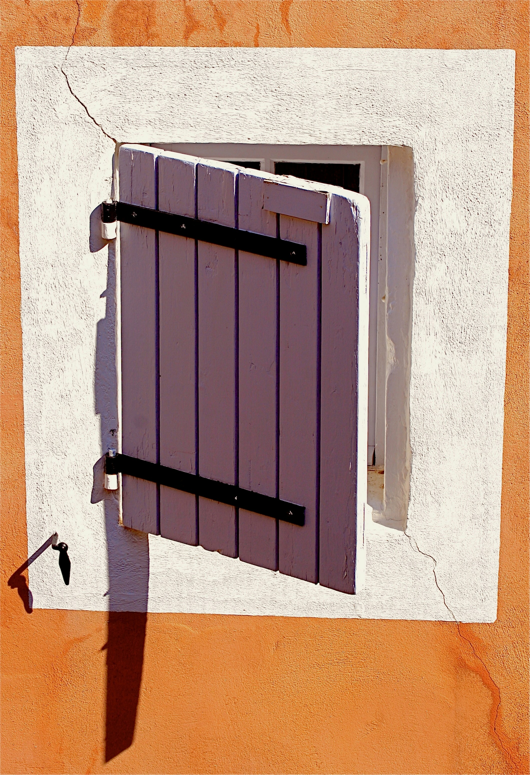 Lavender Shutters on a Sunlit Orange Facade