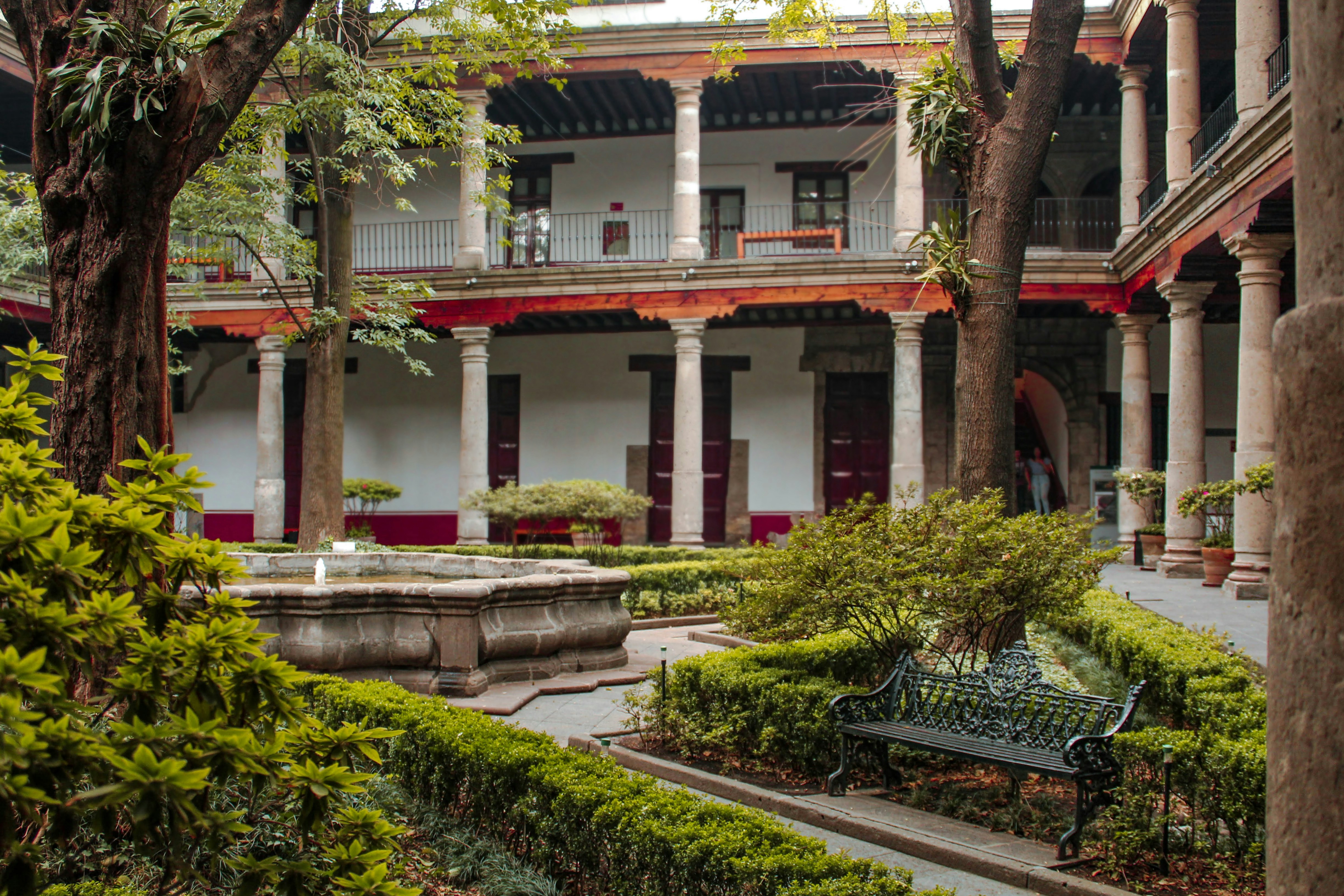 Whispering Courtyard: Fountain Nestled Among Arches and Foliage