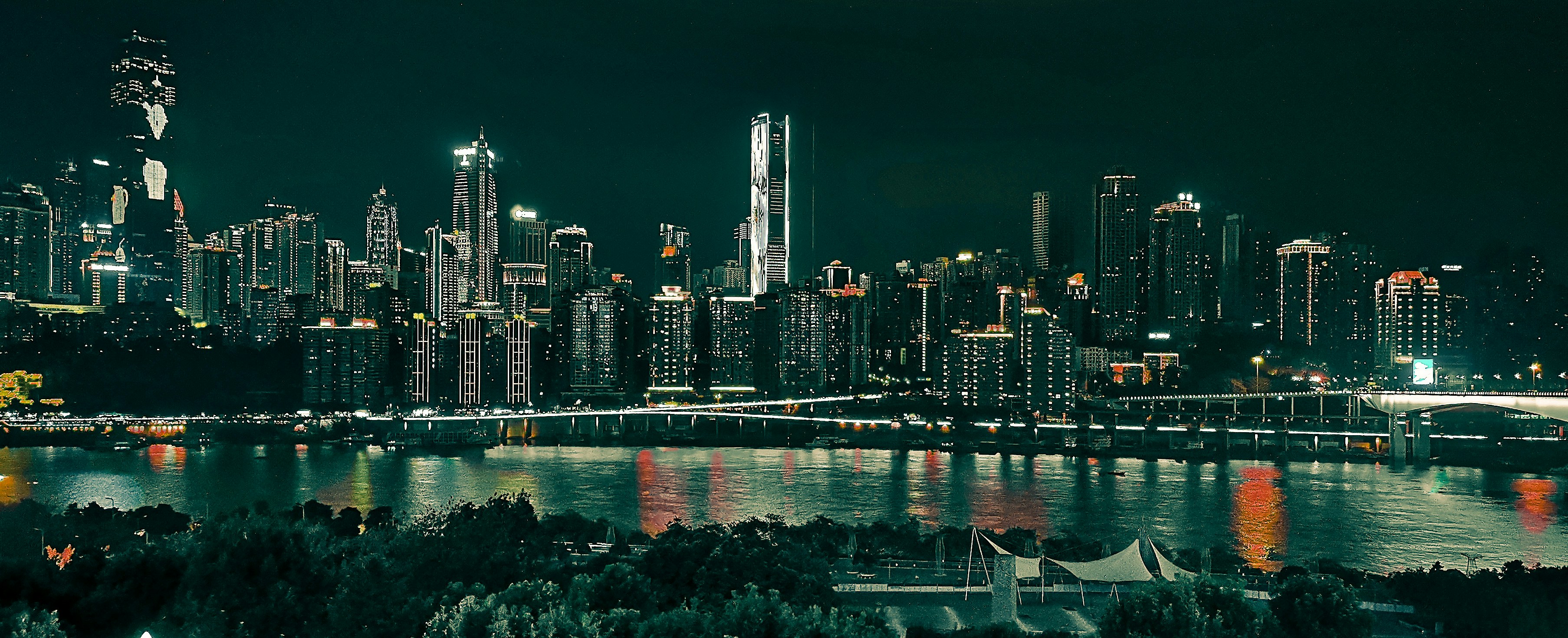 Chongqing's skyline glows vibrantly across the river at night.