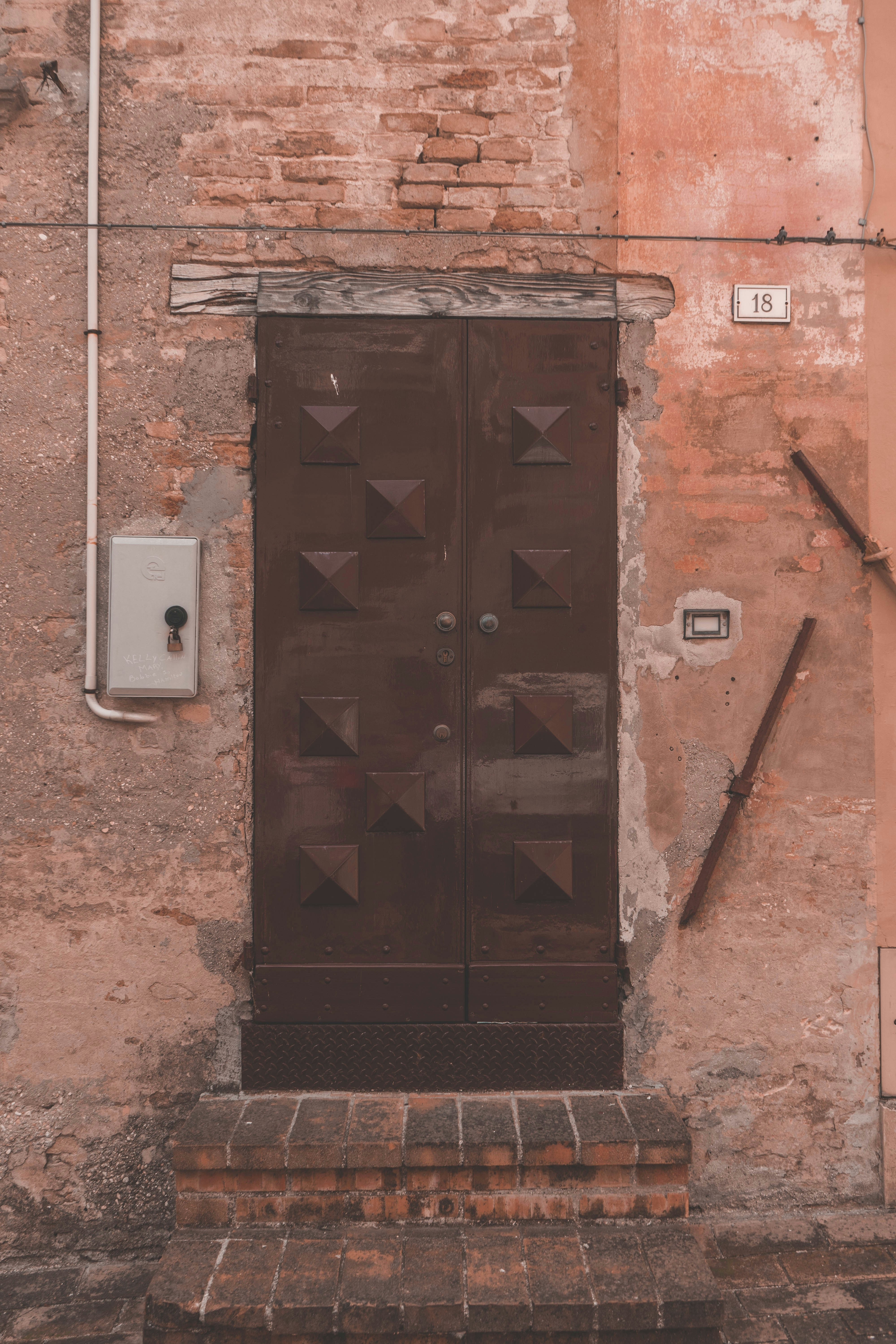 Threshold of Time: A Studded Iron Door Framed by Weathered Brick