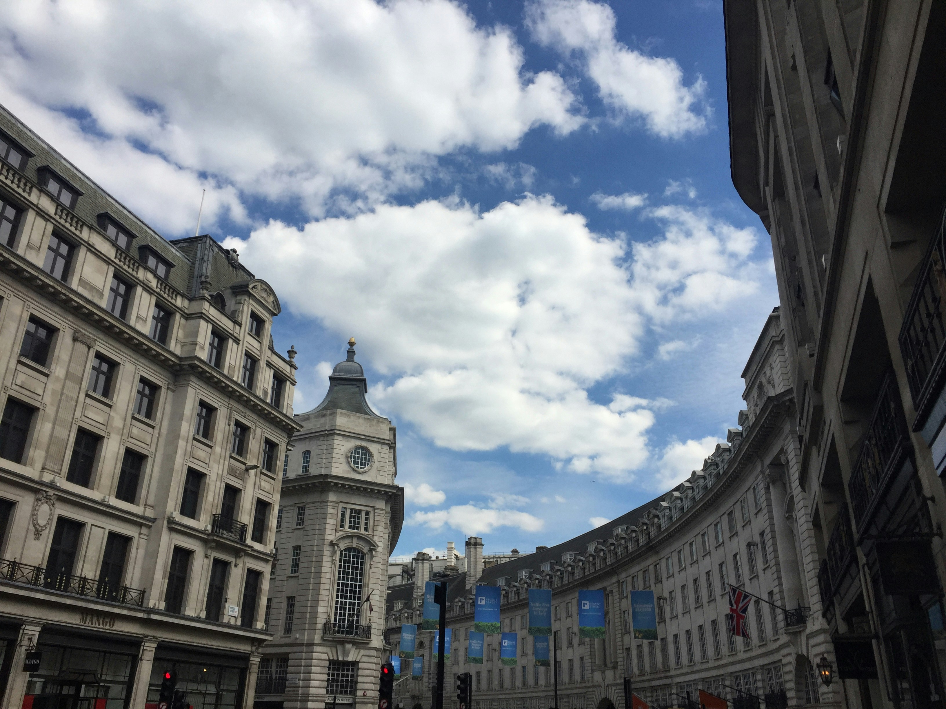 Historic buildings framed by a vibrant sky dotted with clouds, showcasing the architectural beauty of a bustling city.