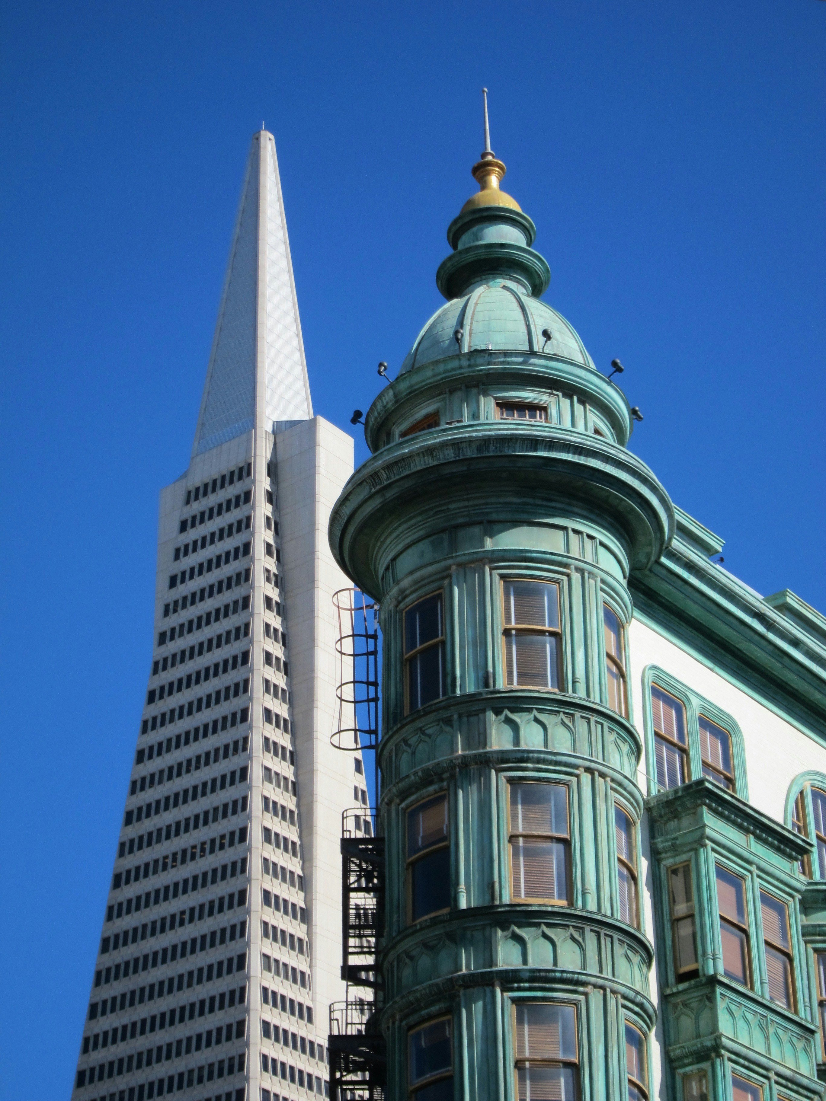 Copper Curve: The Green Turret Standing Tall Against a Modern Spire