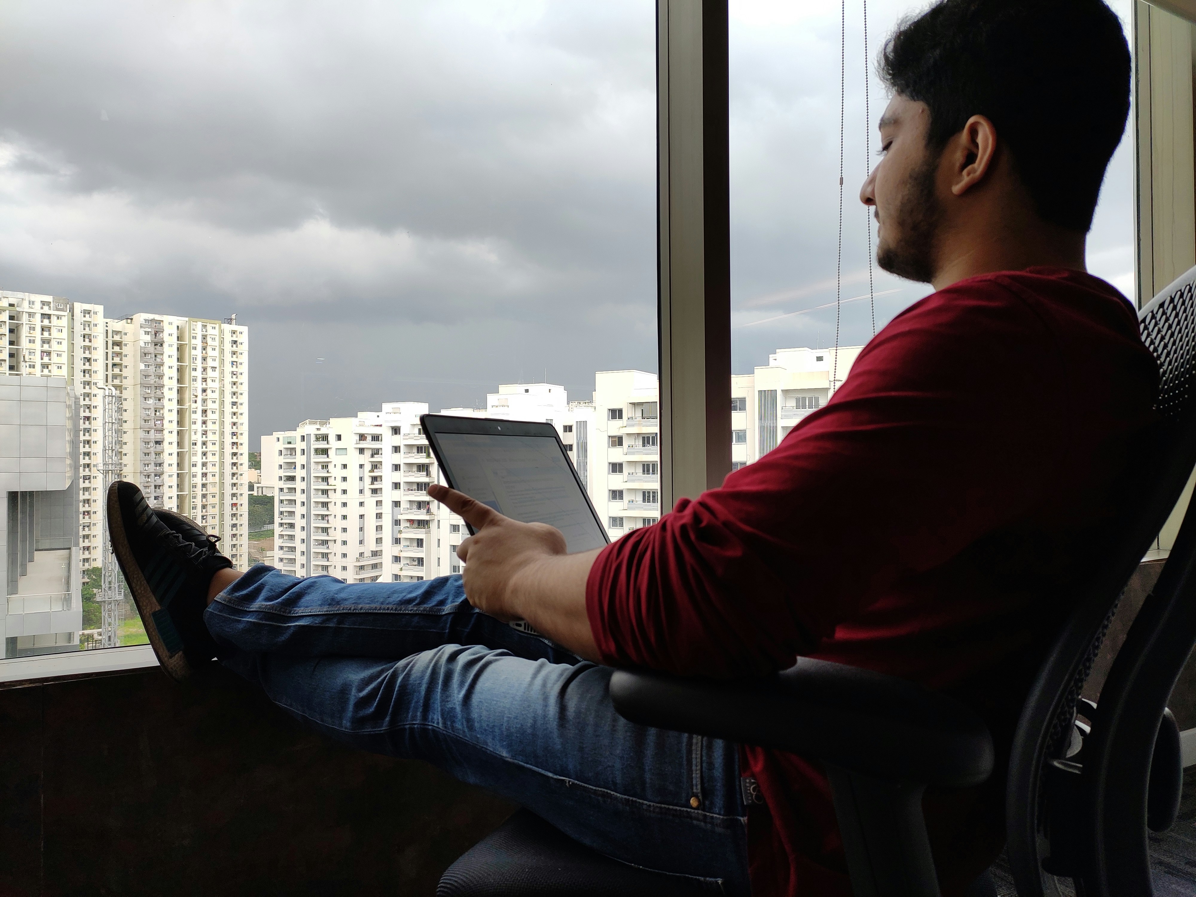 Man sitting beside window photo – Free Jayabheri orange towers Image on ...