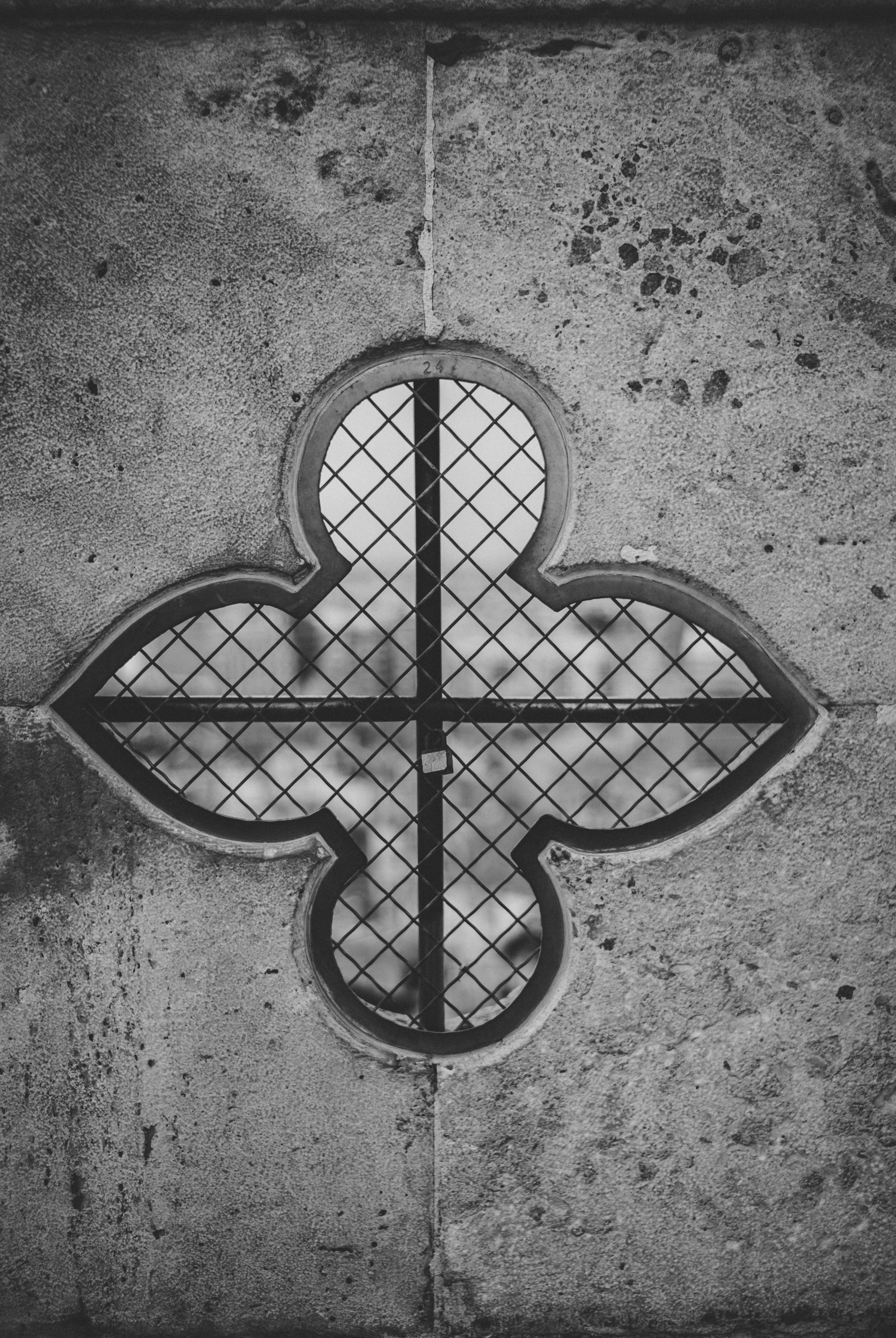 a black and white photo of a cross on a wall