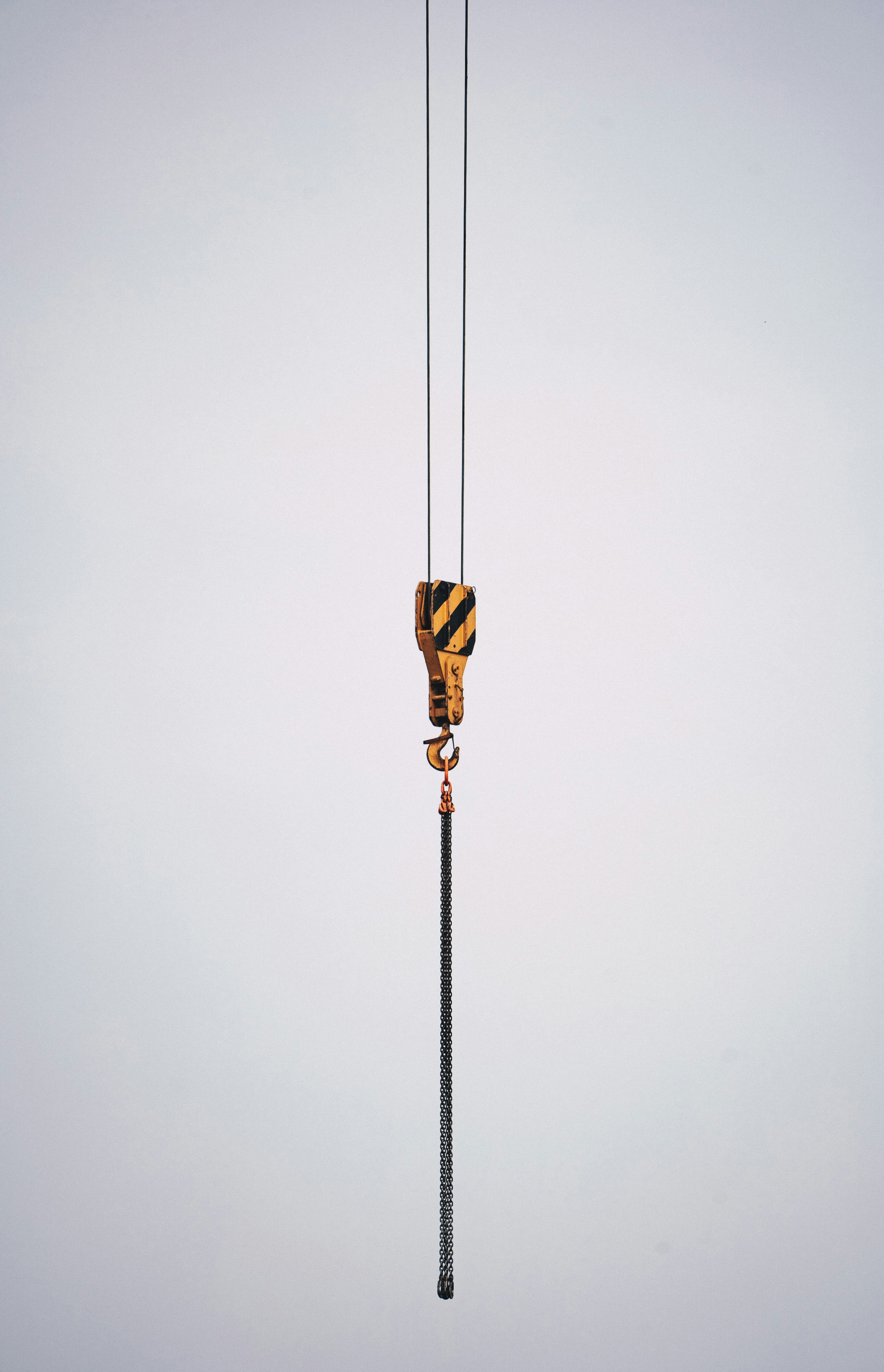 Yellow-Striped Crane Hook Dangles in an Expansive Pale Sky