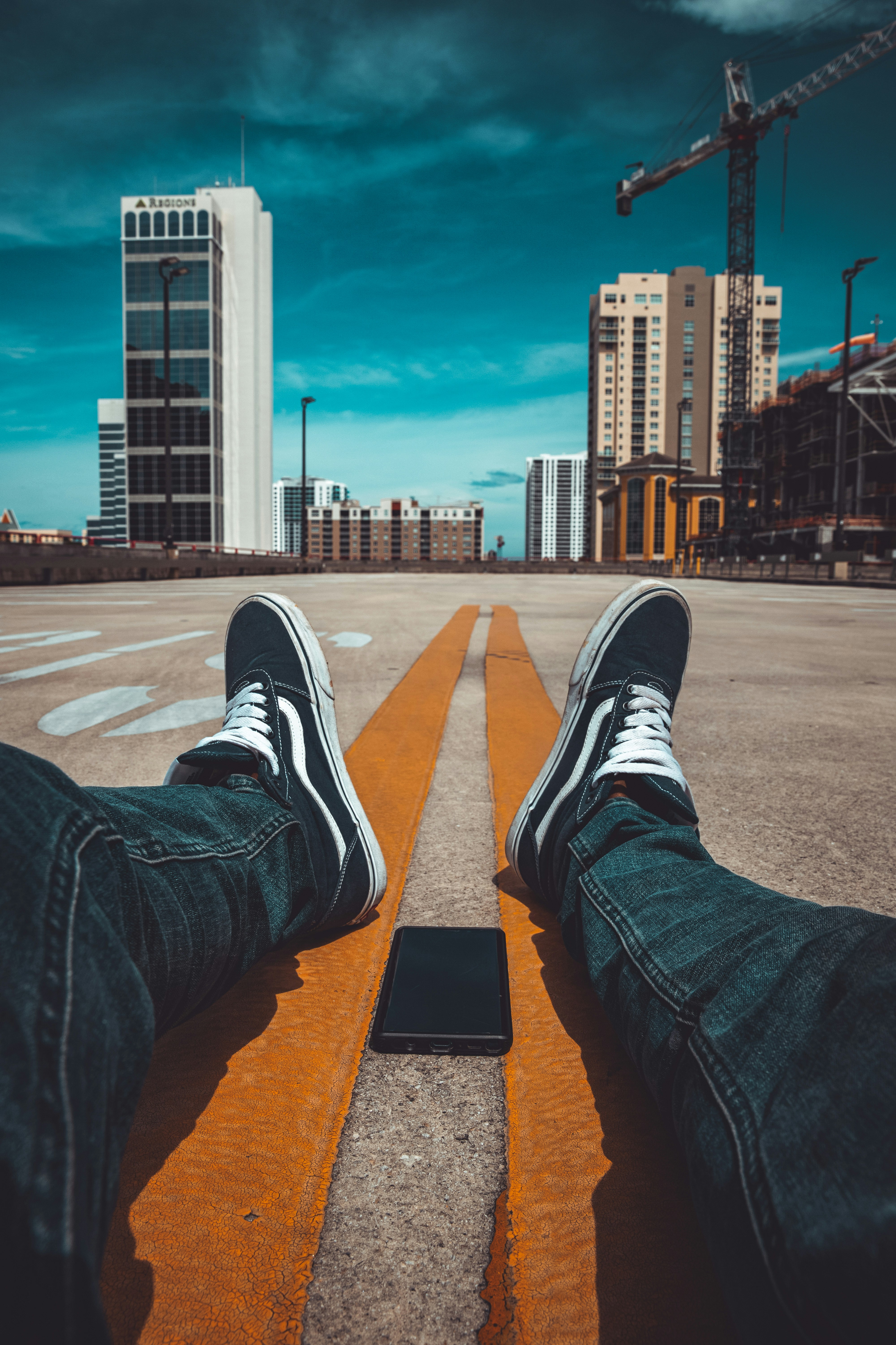 Grounded in the City: Sneakers Rest on an Orange Lane with Skyline Reach
