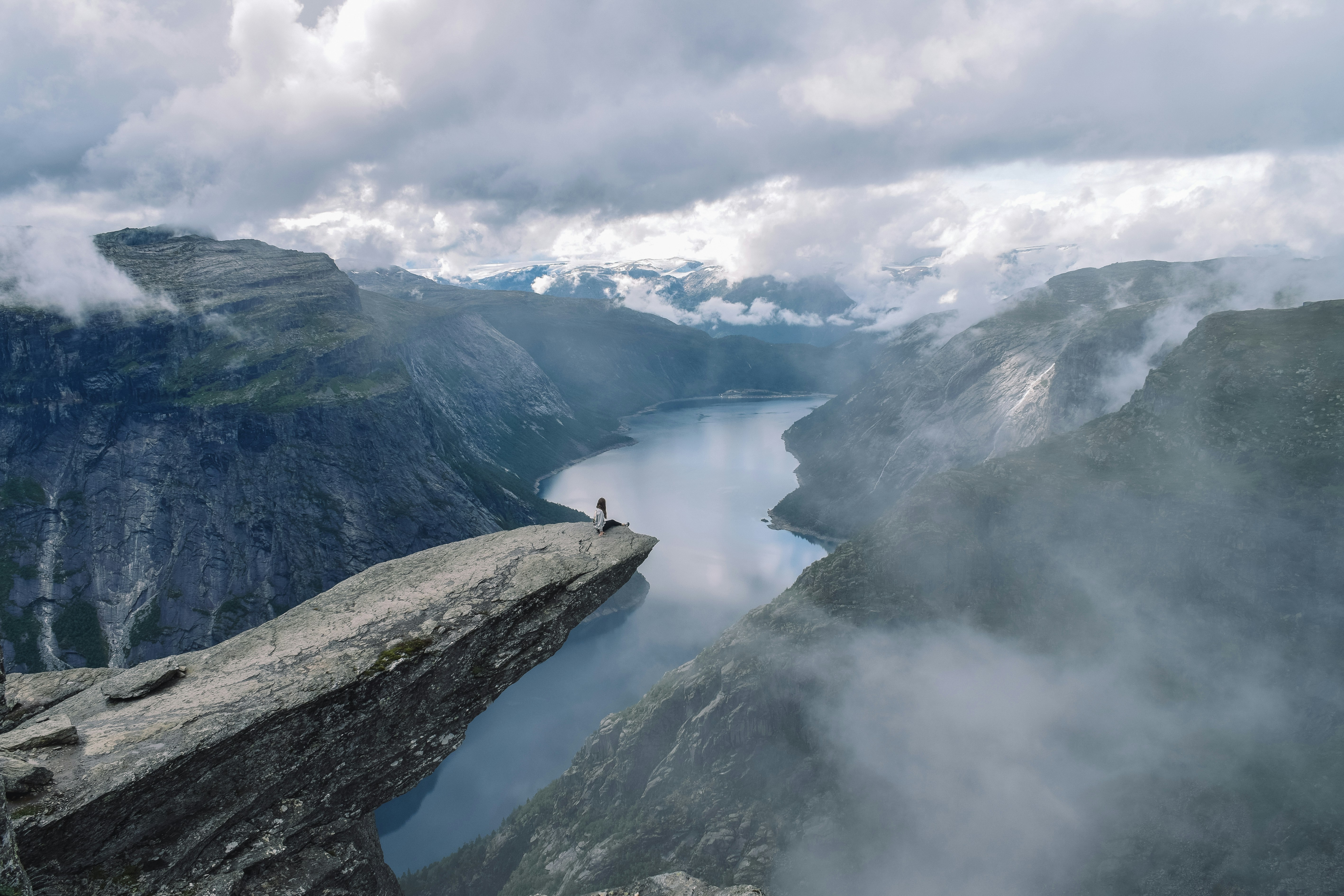 Person at a gray cliff overlooking a river photo – Free Norway Image on ...