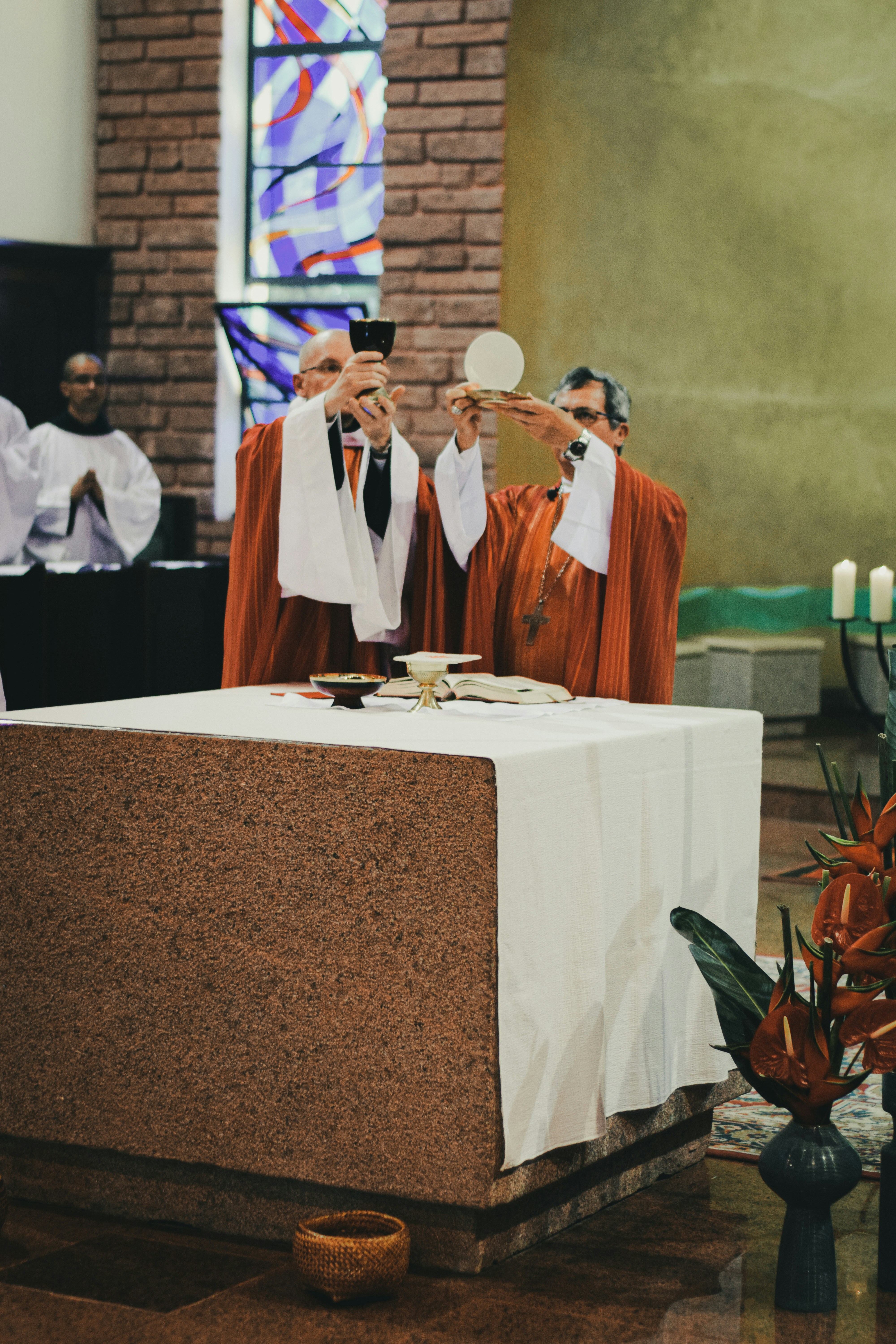 Ritual of the Circle: Clergy Elevate the Eucharist before Stained Glass