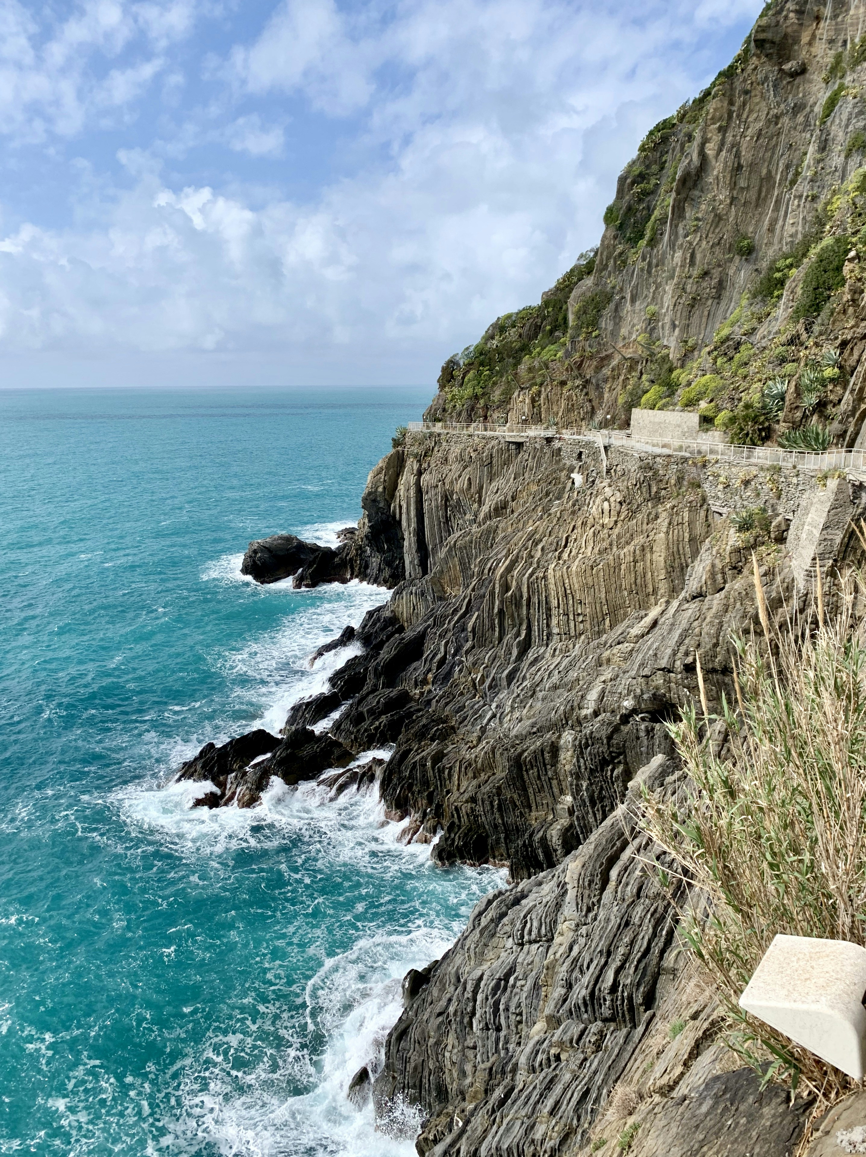 Cliffside Ribbon: a narrow coastal road tracing jagged rock above turquoise seas