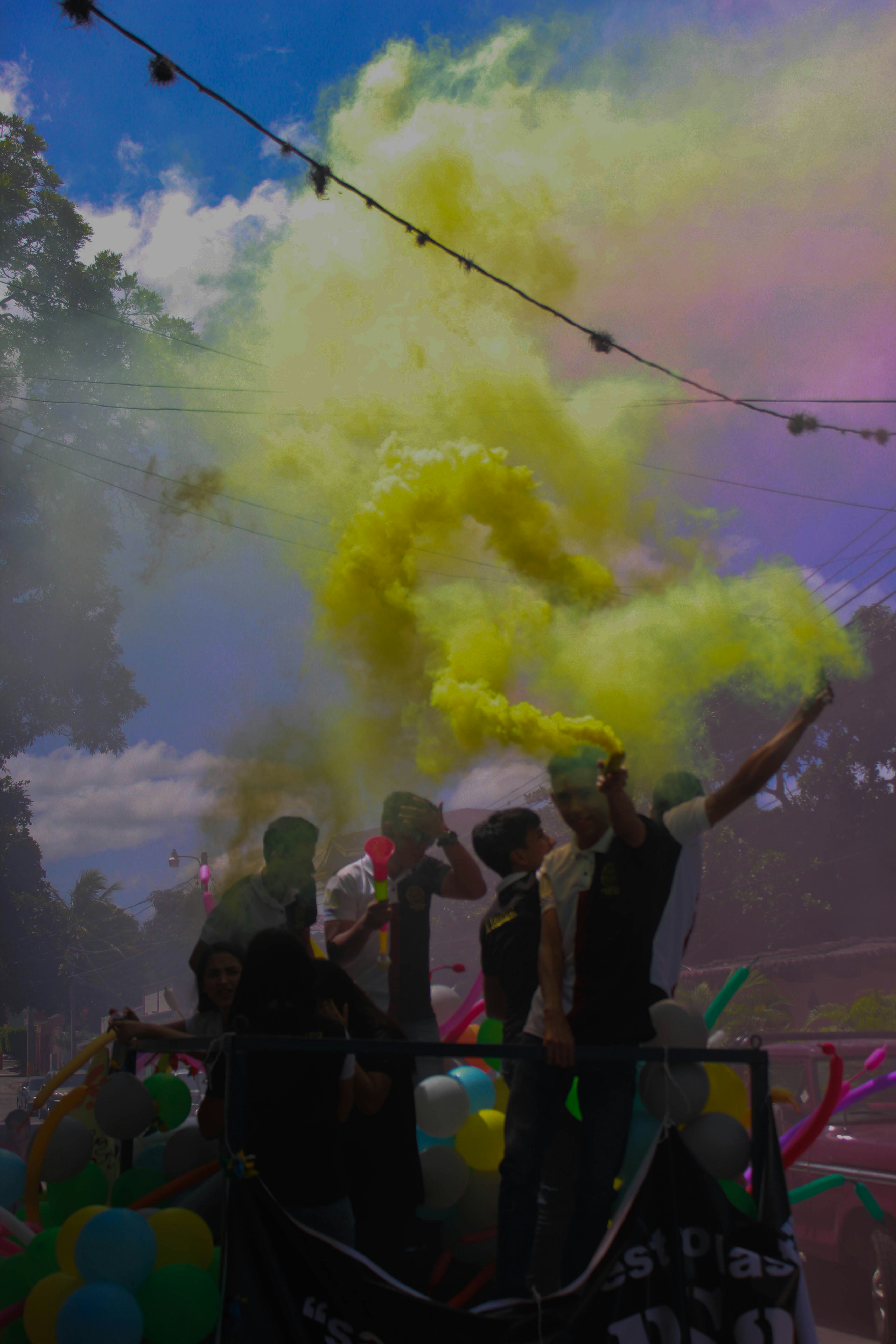 Group of people on top of vehicle throwing powders photo – Free Car ...
