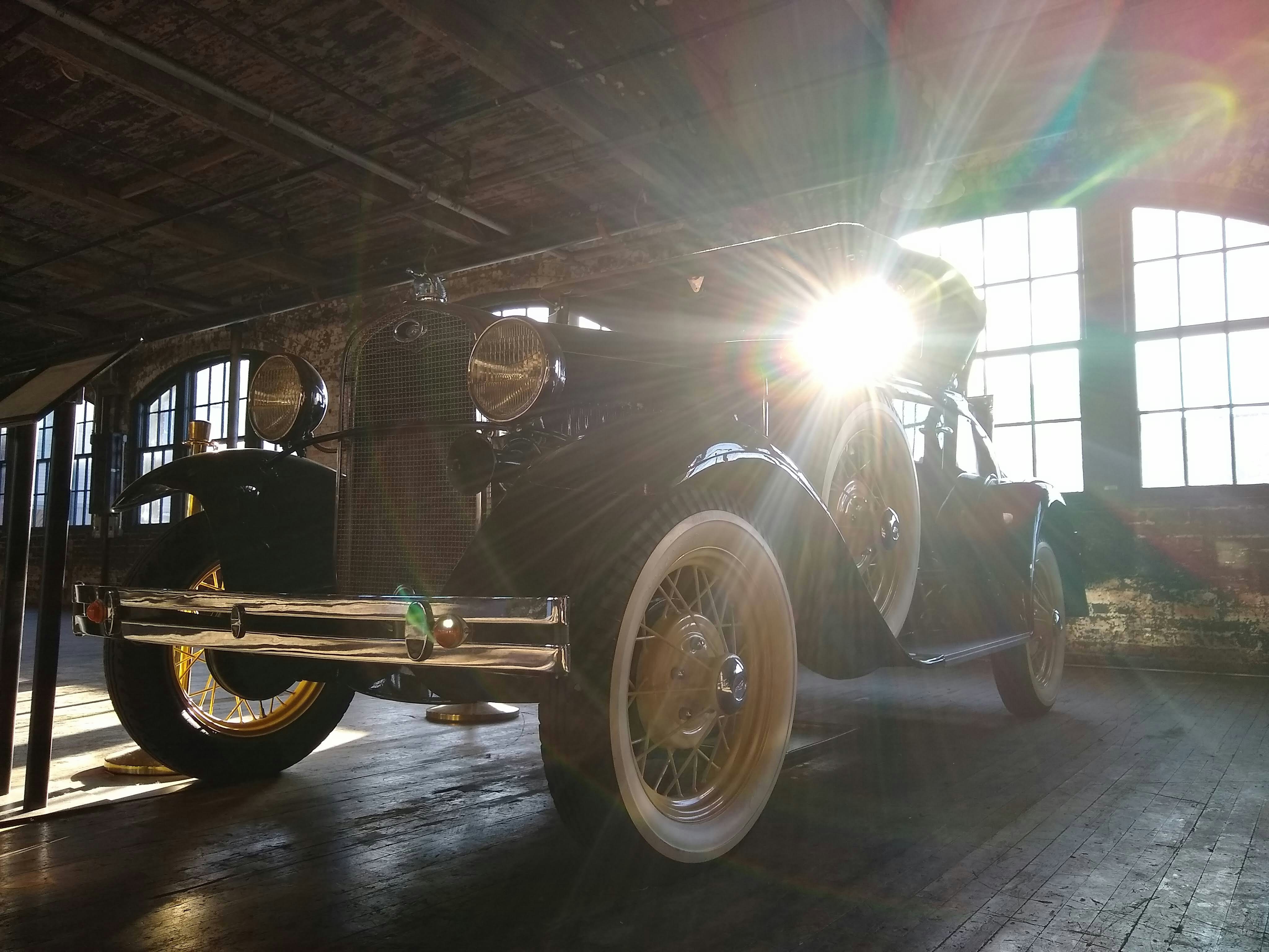 Classic car bathed in sunlight within an industrial loft space.