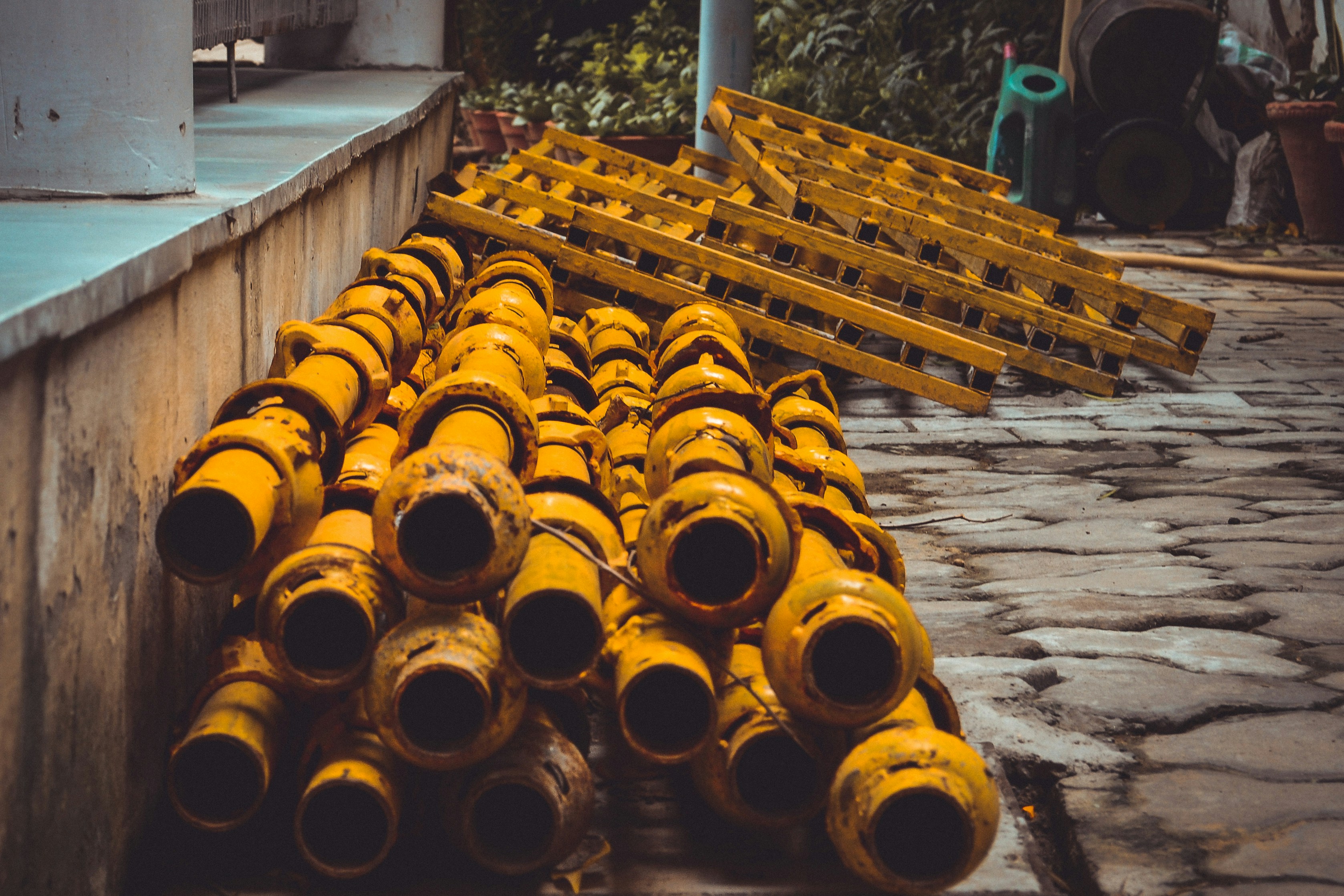 Rows of Yellow Pipe Caps Resting Along a Weathered Pavement