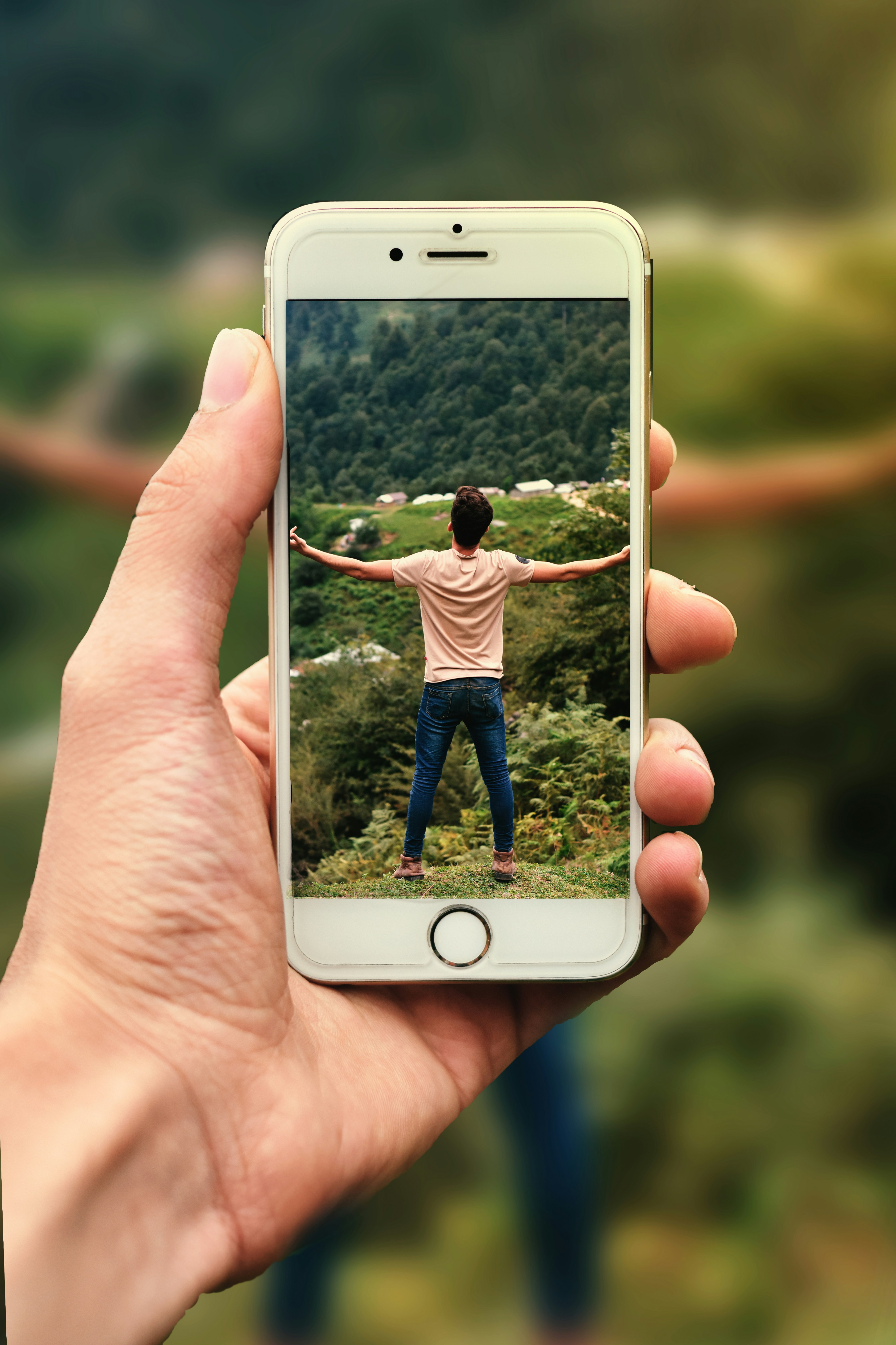 Palm-Side Summit: A Man with Arms Outstretched Framed by a Verdant Valley