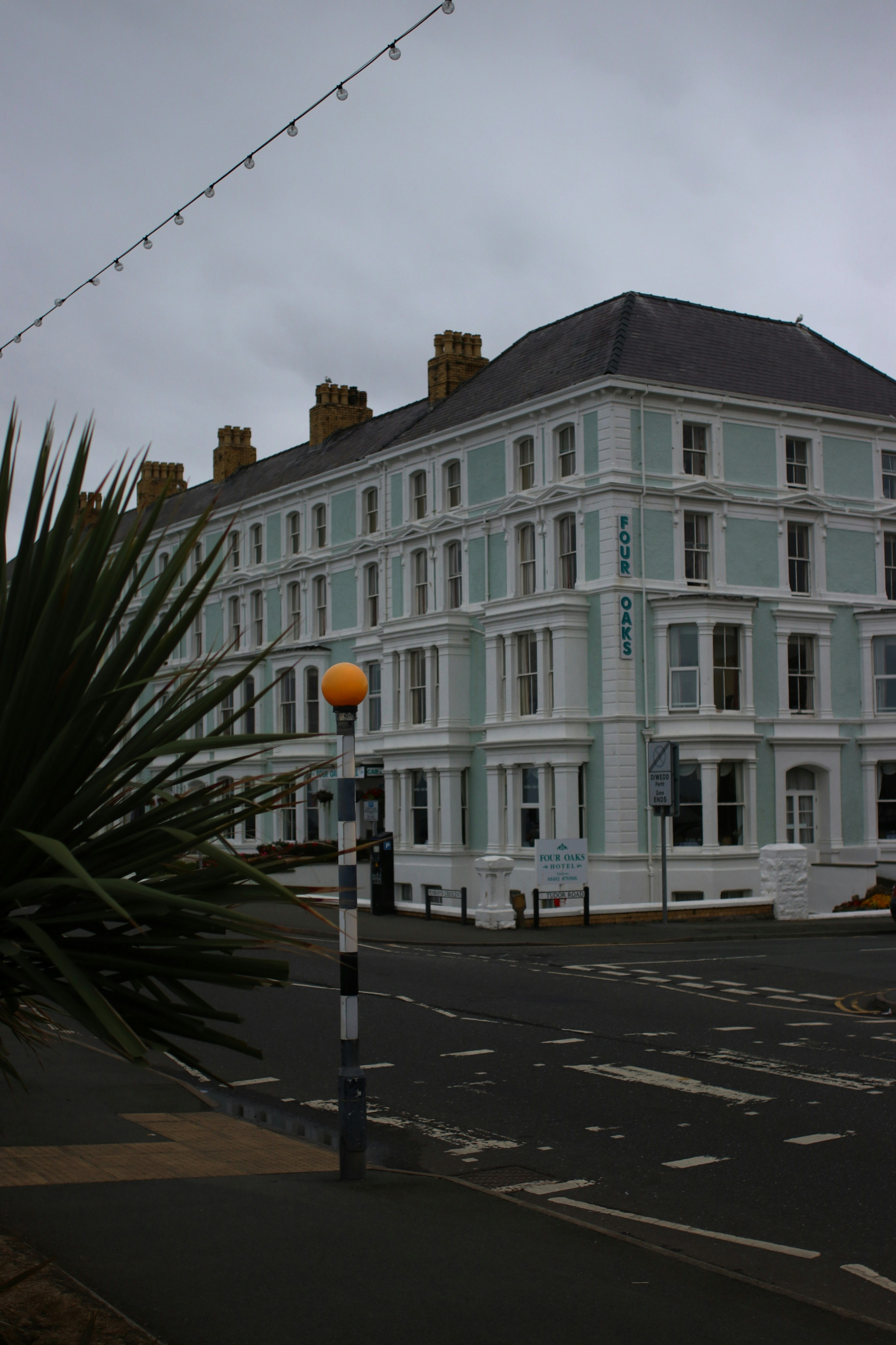 Orange Beacon Over a Mint-Blue Terrace: A Quiet Coastal Street
