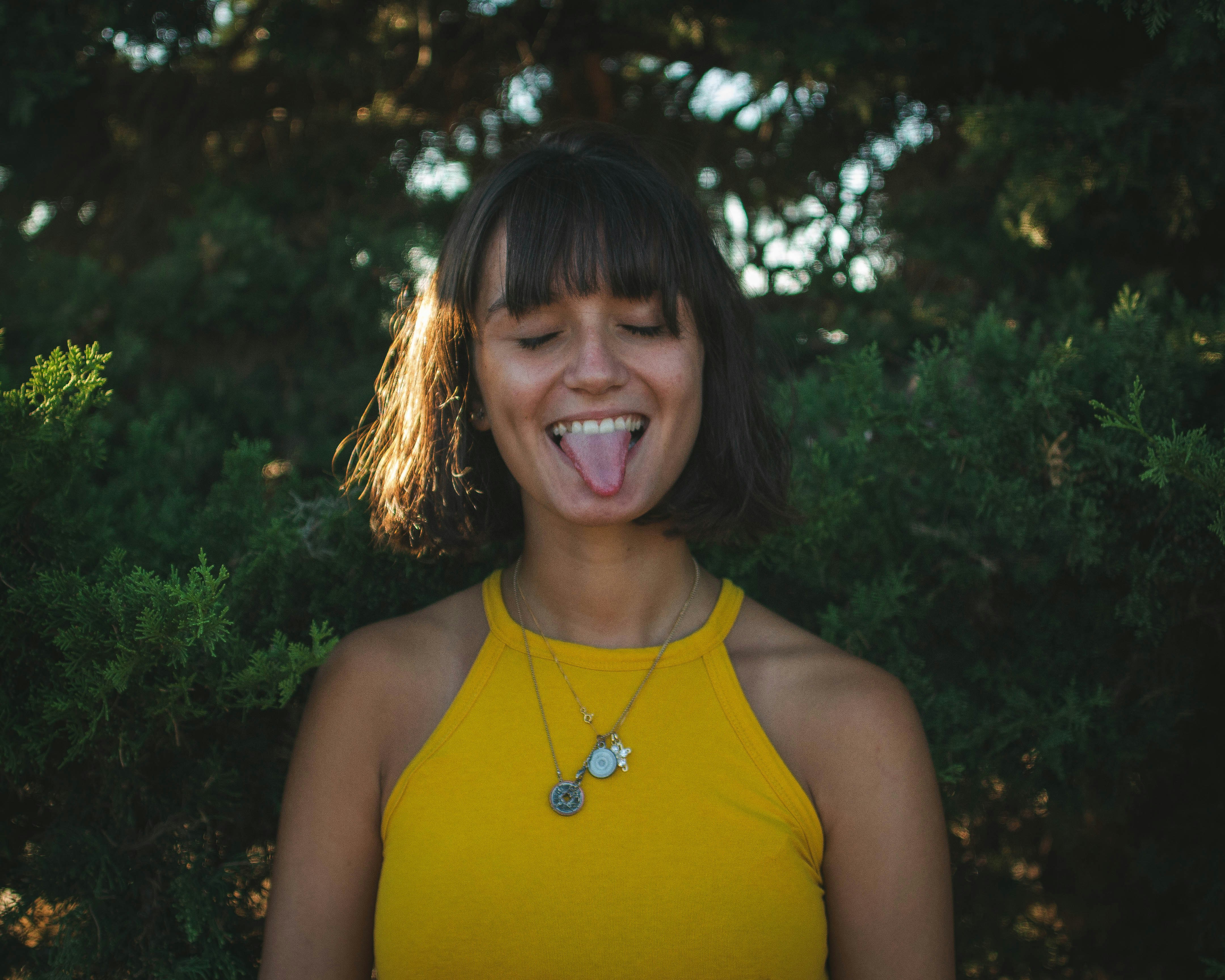 Yellow Top, Quiet Greens: A Playful Portrait in Soft Backlight