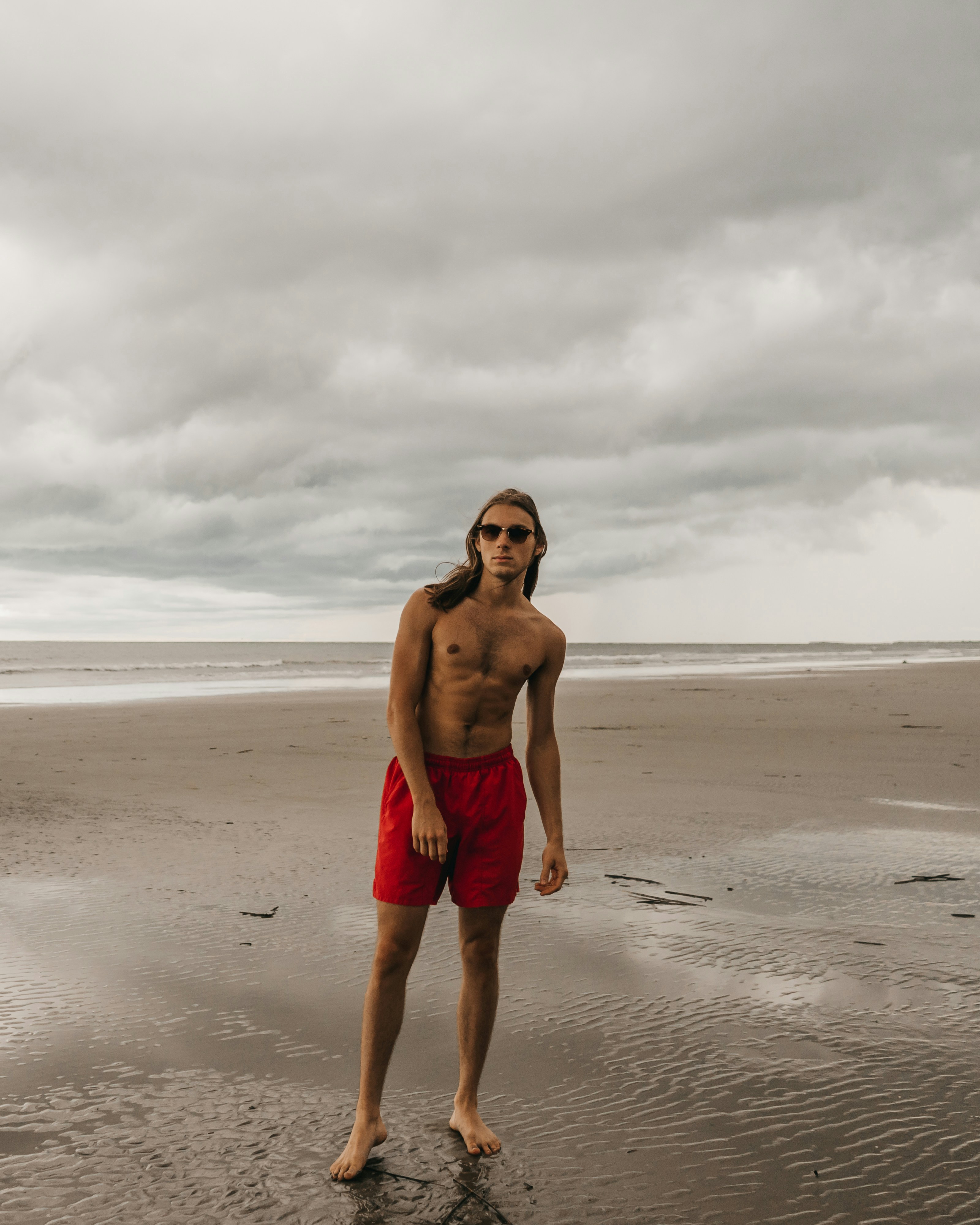 Coastal Silence: A Surfer in Red on a Windy Shore