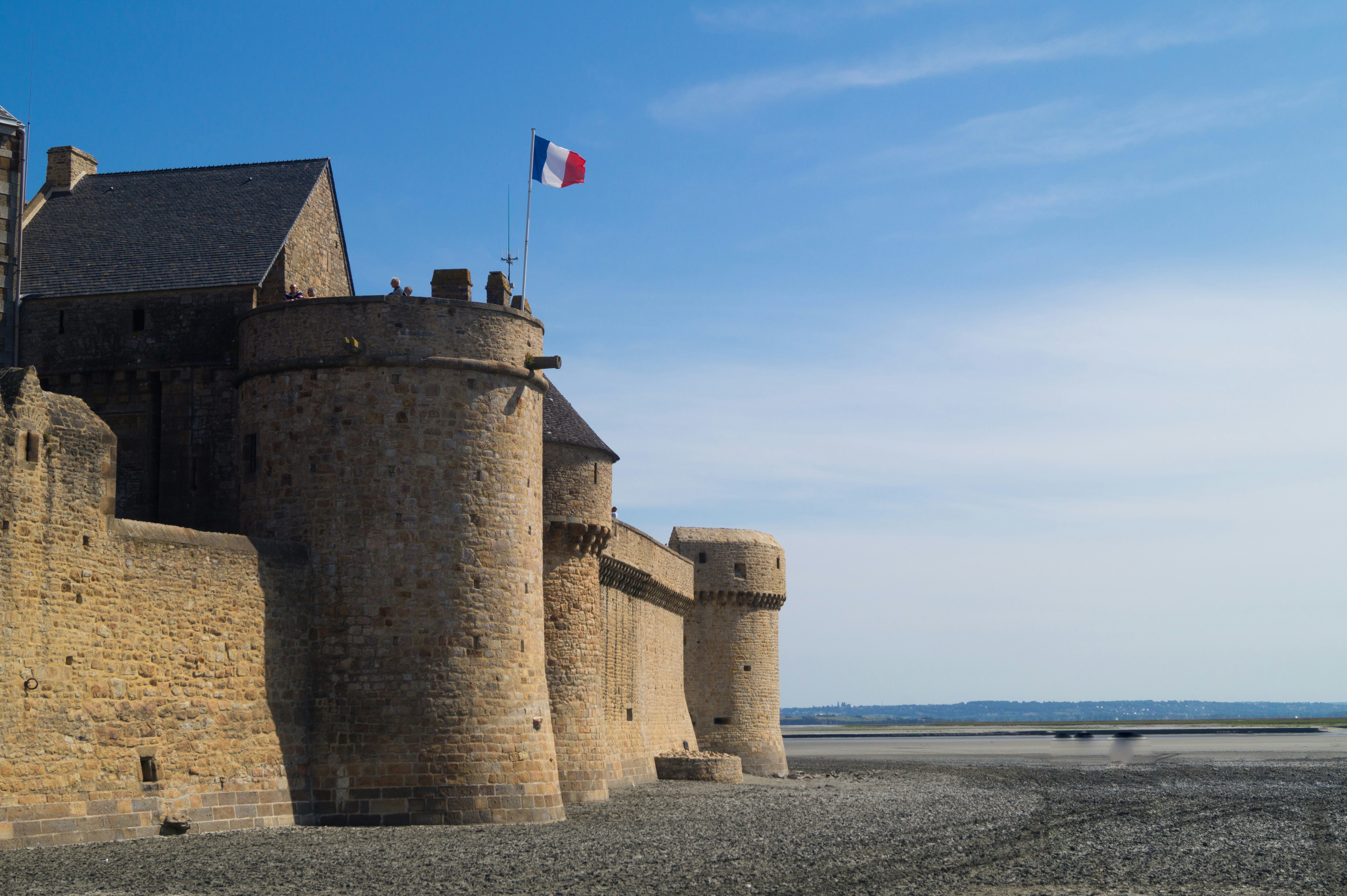 Flagged Bastion at the Shore: Sunlit Stones Guarding the Quiet Tide