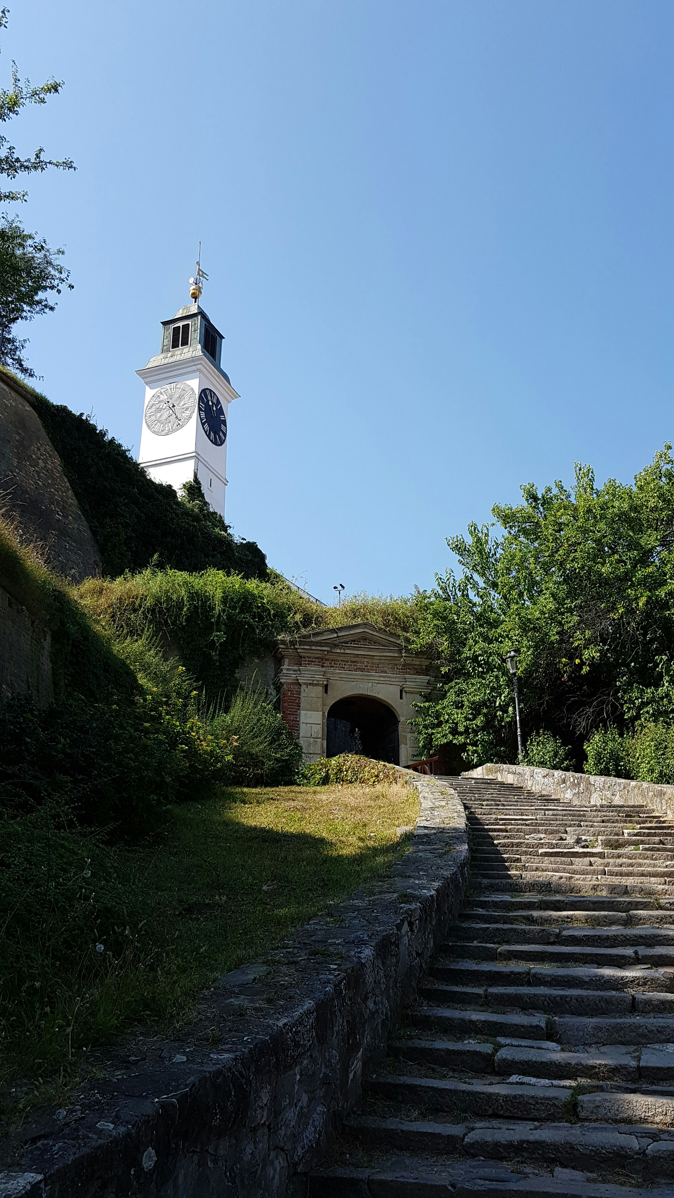A Timeless Watcher: Clock Tower Above the Winding Stone Staircase