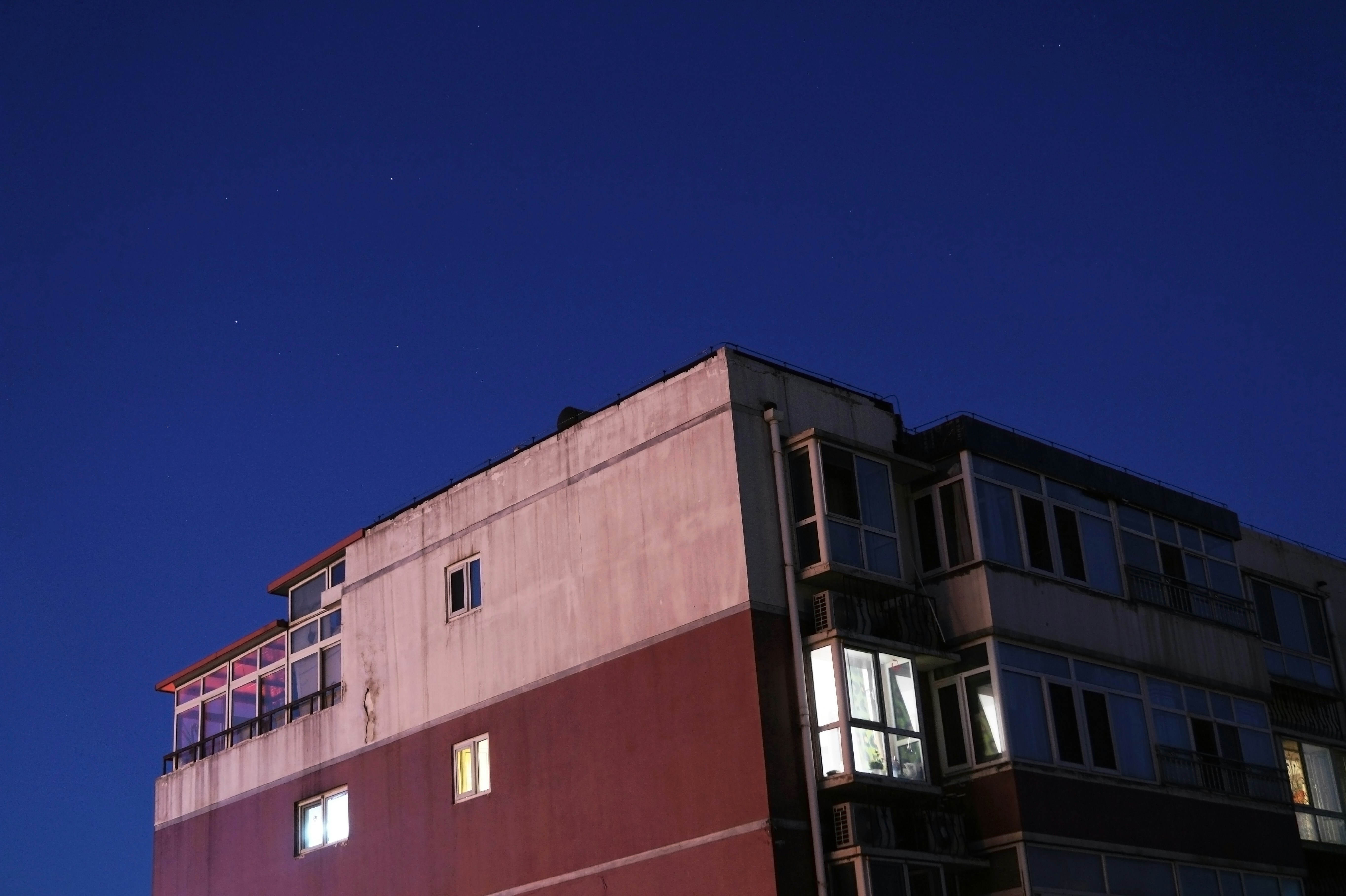 Midnight Geometry: A Red-Panel Block Lit by Quiet Windows