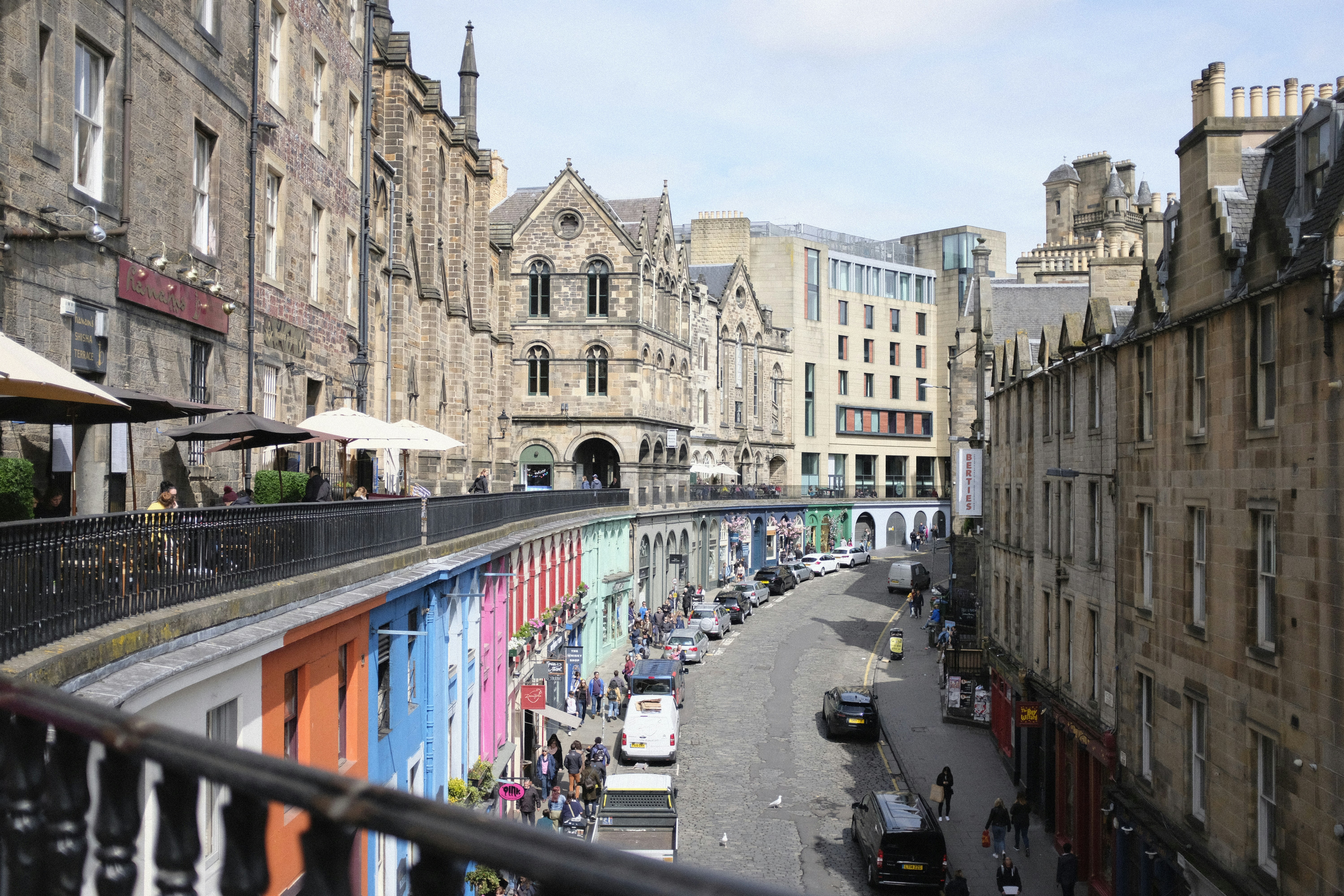 Victoria Street's colorful buildings curve gracefully in Edinburgh's old town under a clear sky.