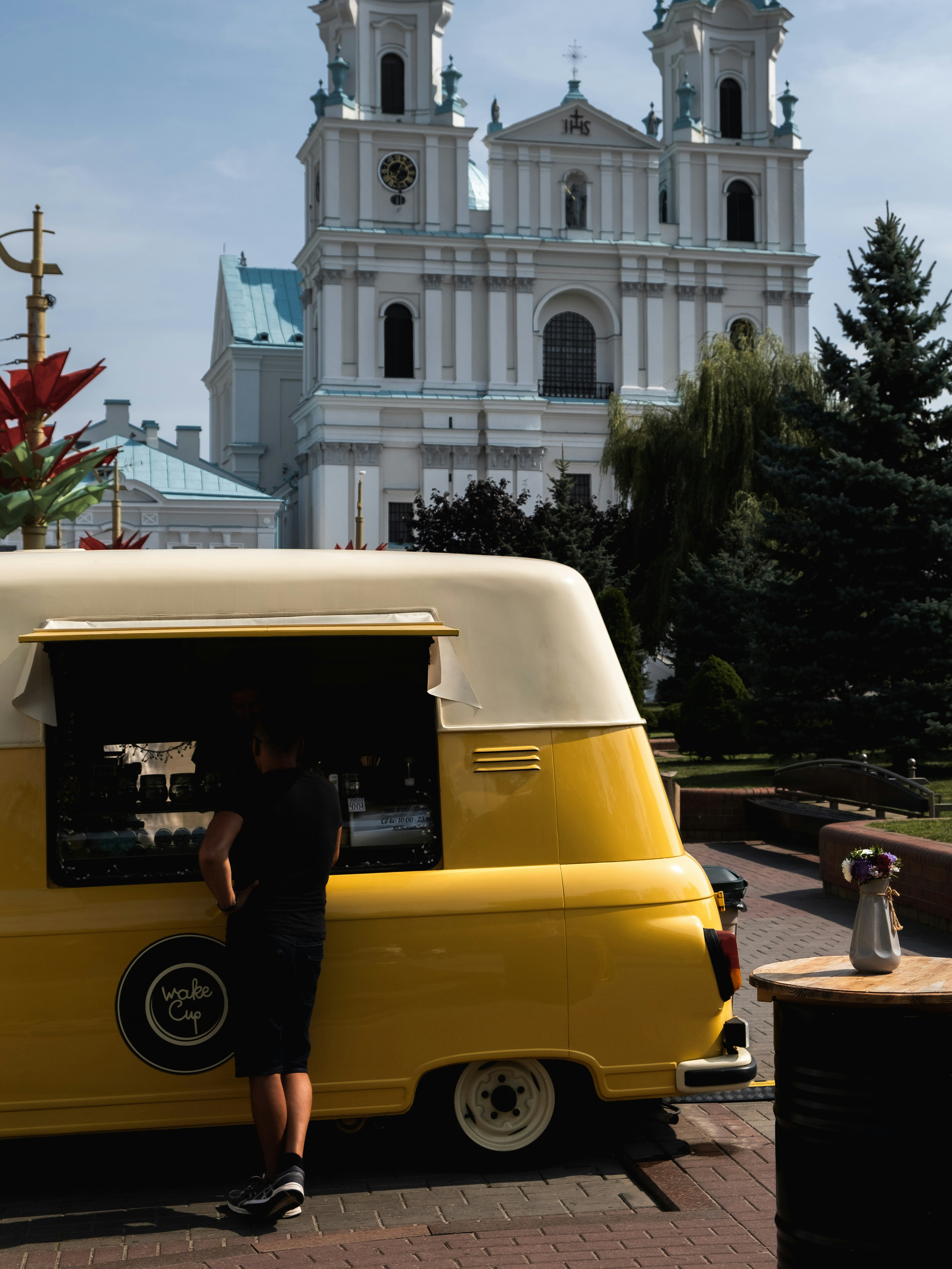 Sunlit Yellow Van Framing a White Cathedral