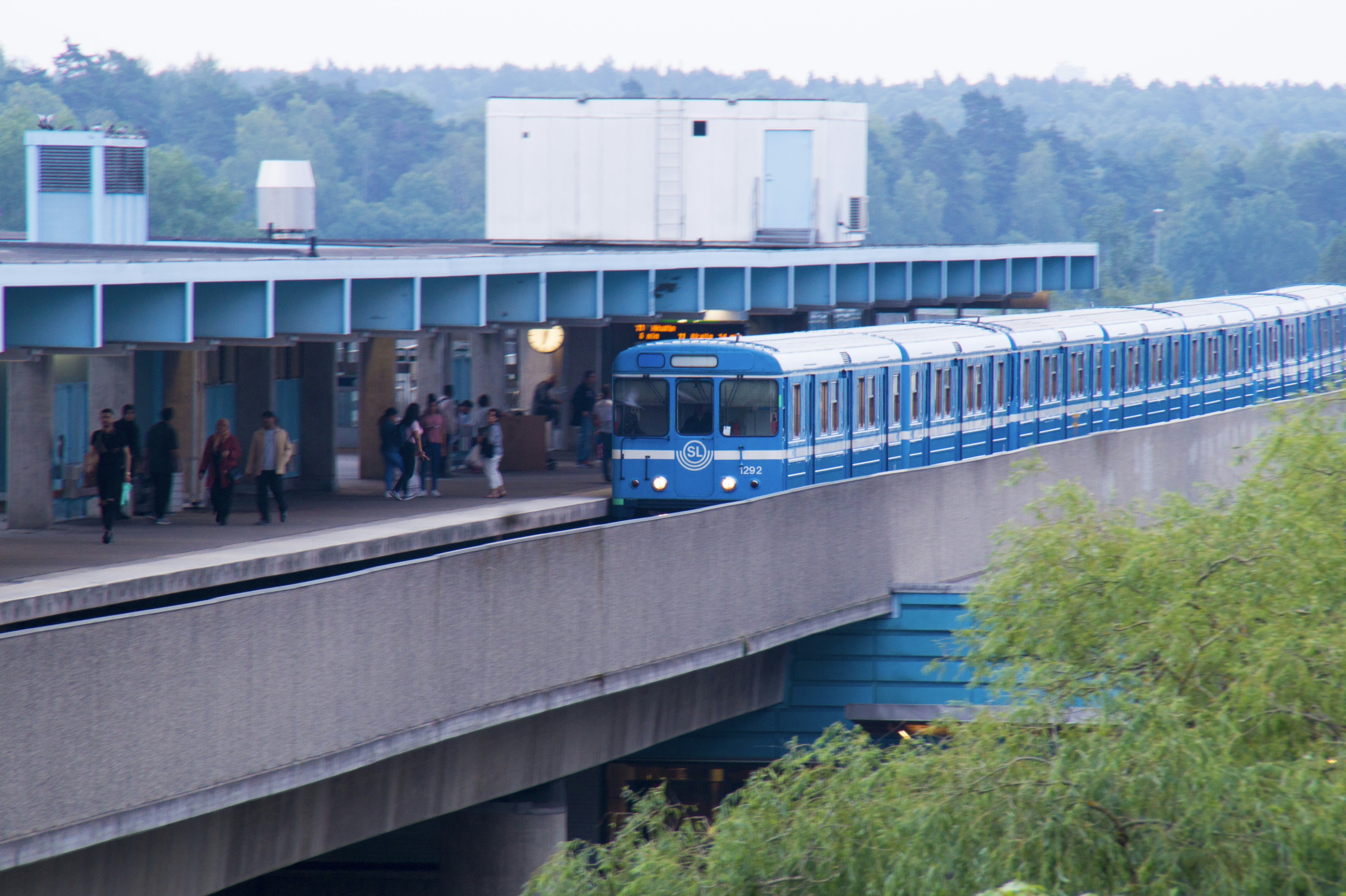 A blue and white train pulling into a train station photo – Free Kista metro station Image on ...