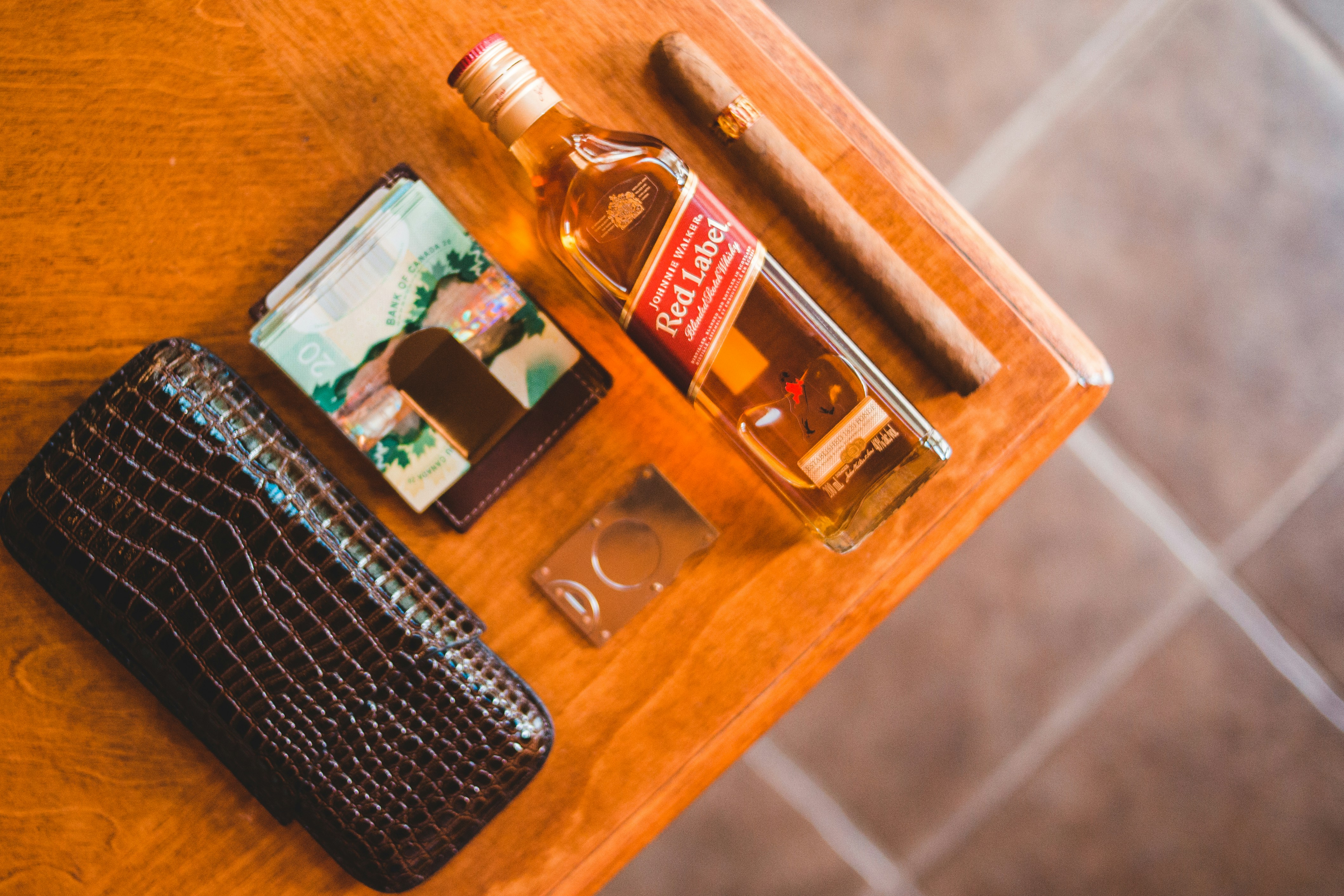 Red Label bottle tobacco and wallet on table photo – Free Furniture ...