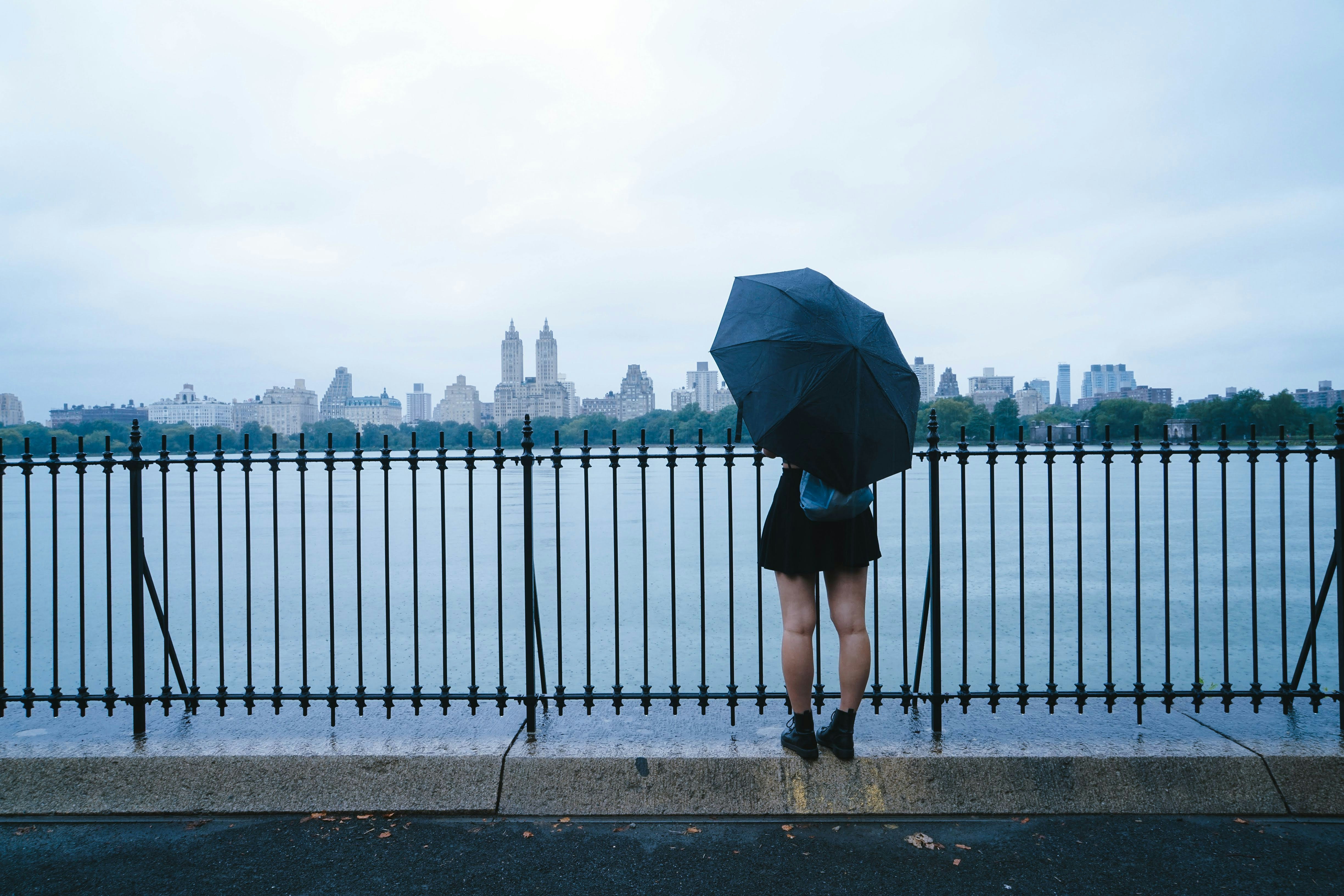 person holding umbrella near sea
