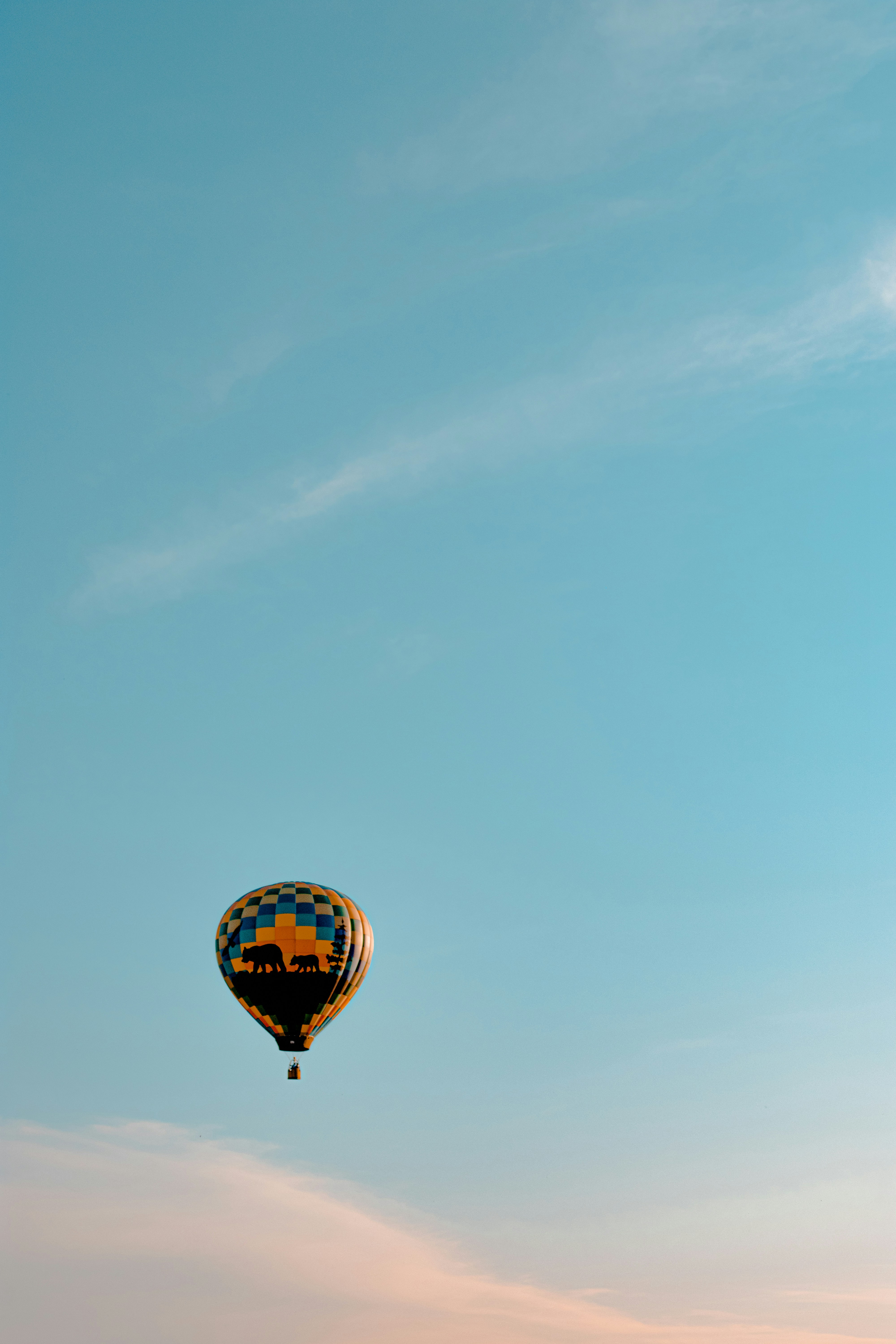 Cerulean Drift: A Checkered Balloon Traverses the Quiet Sky