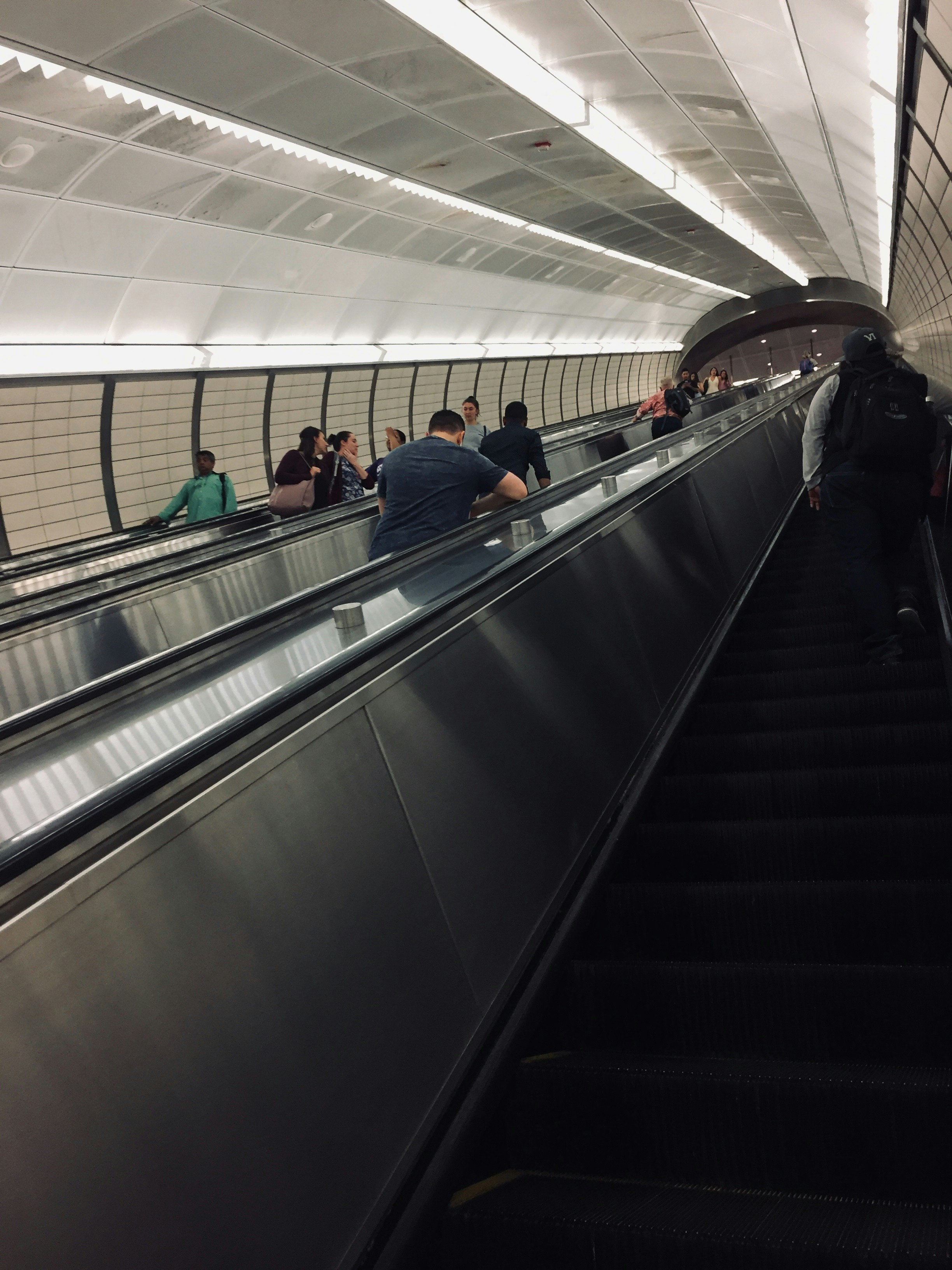 A group of people riding down an escalator photo – Free 34th street ...