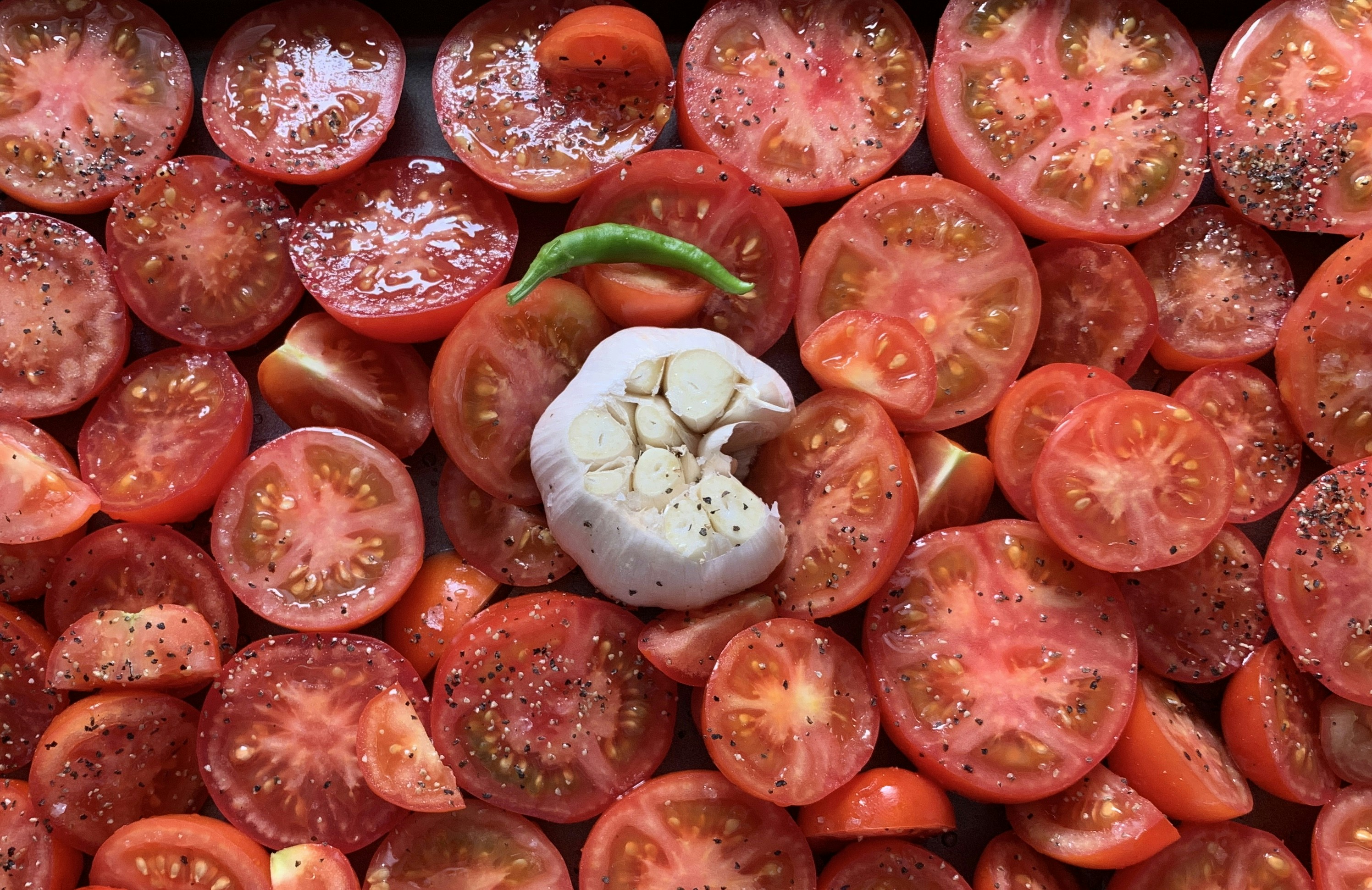Center Garnish: A Garlic-Clove Crown Amid Red Tomato Orbs