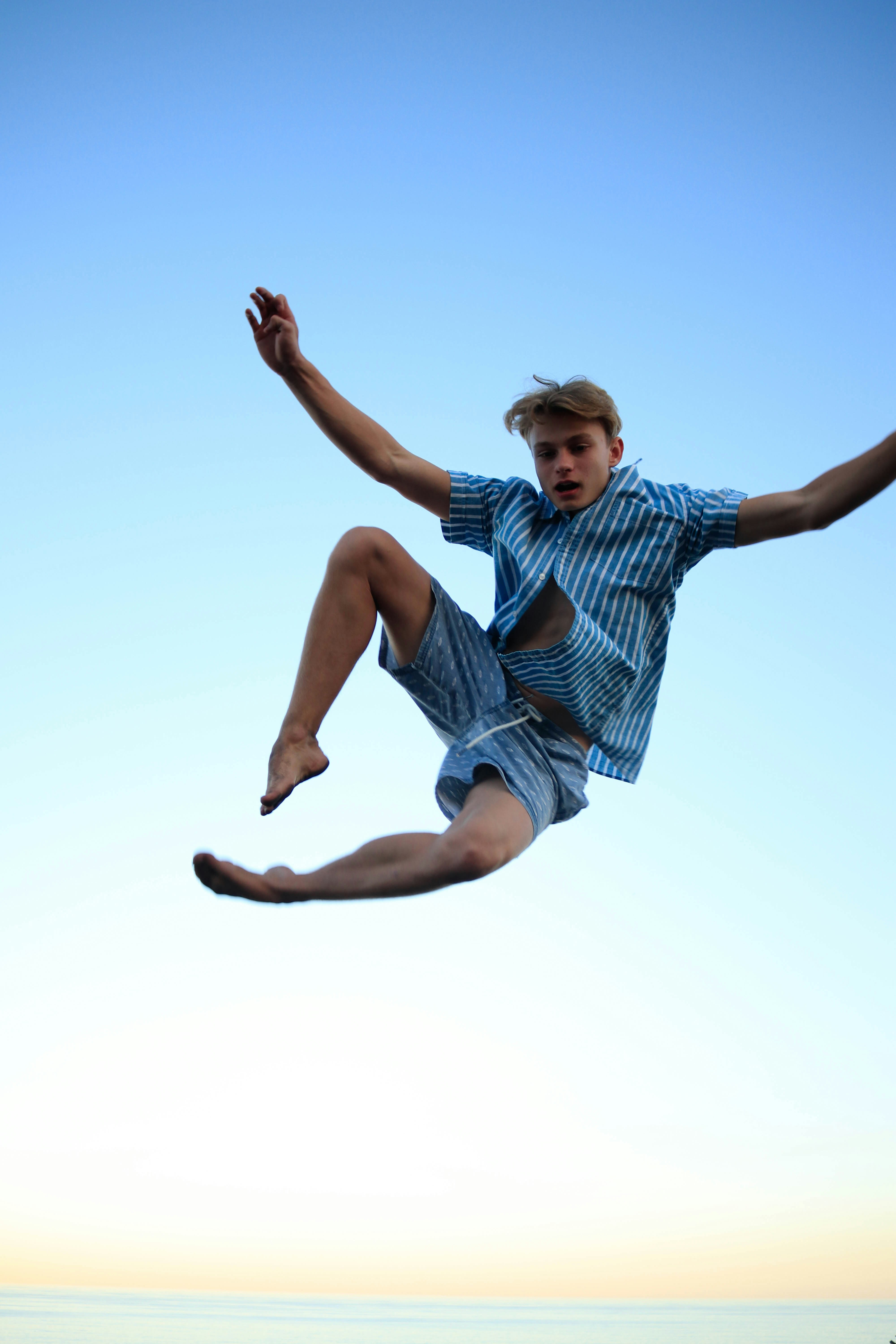 Skybound in Stripes: Barefoot Leap Above a Quiet Horizon