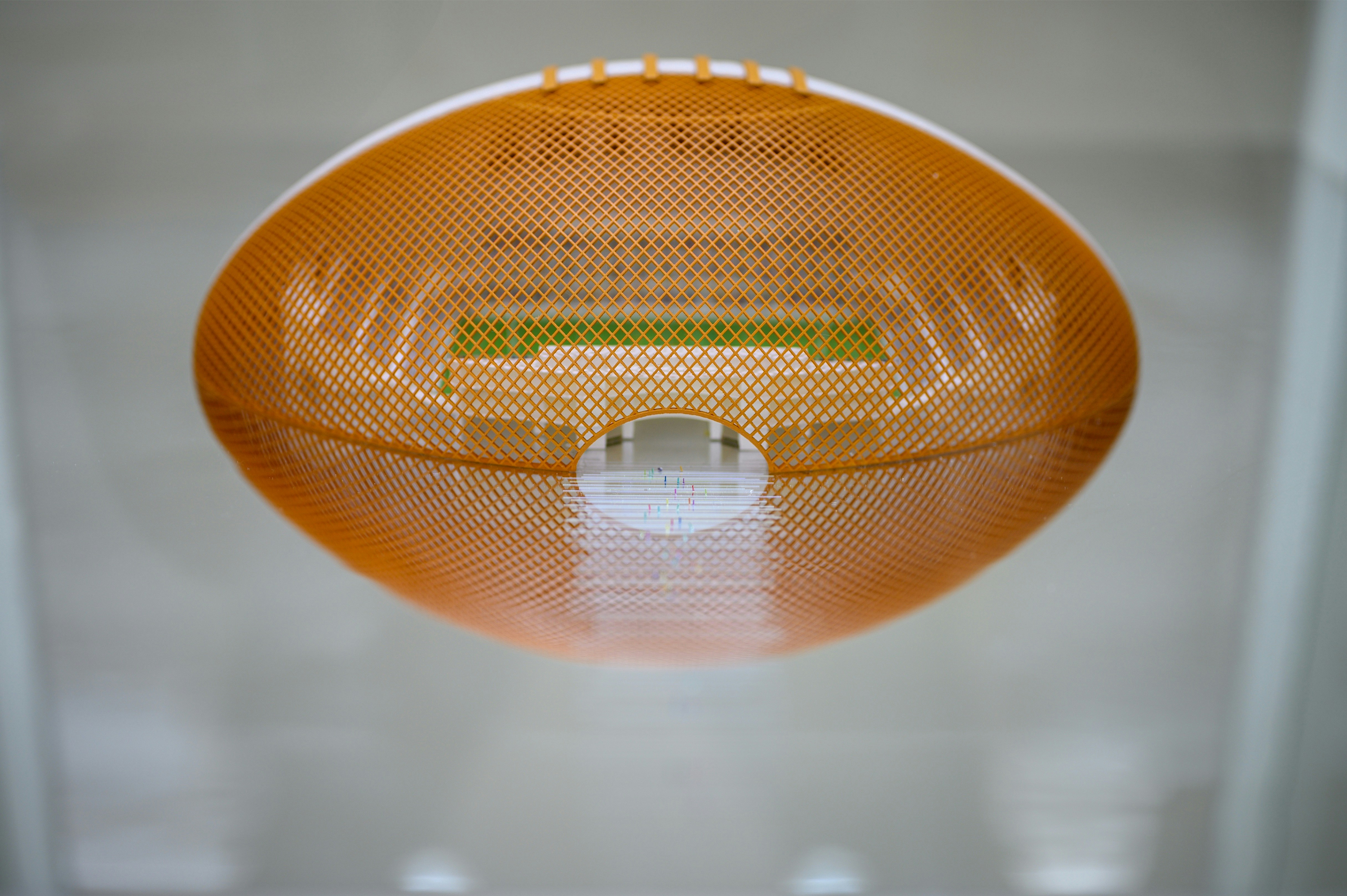 Lattice Orange: Close-Up of a Perforated Basketball Through Glass