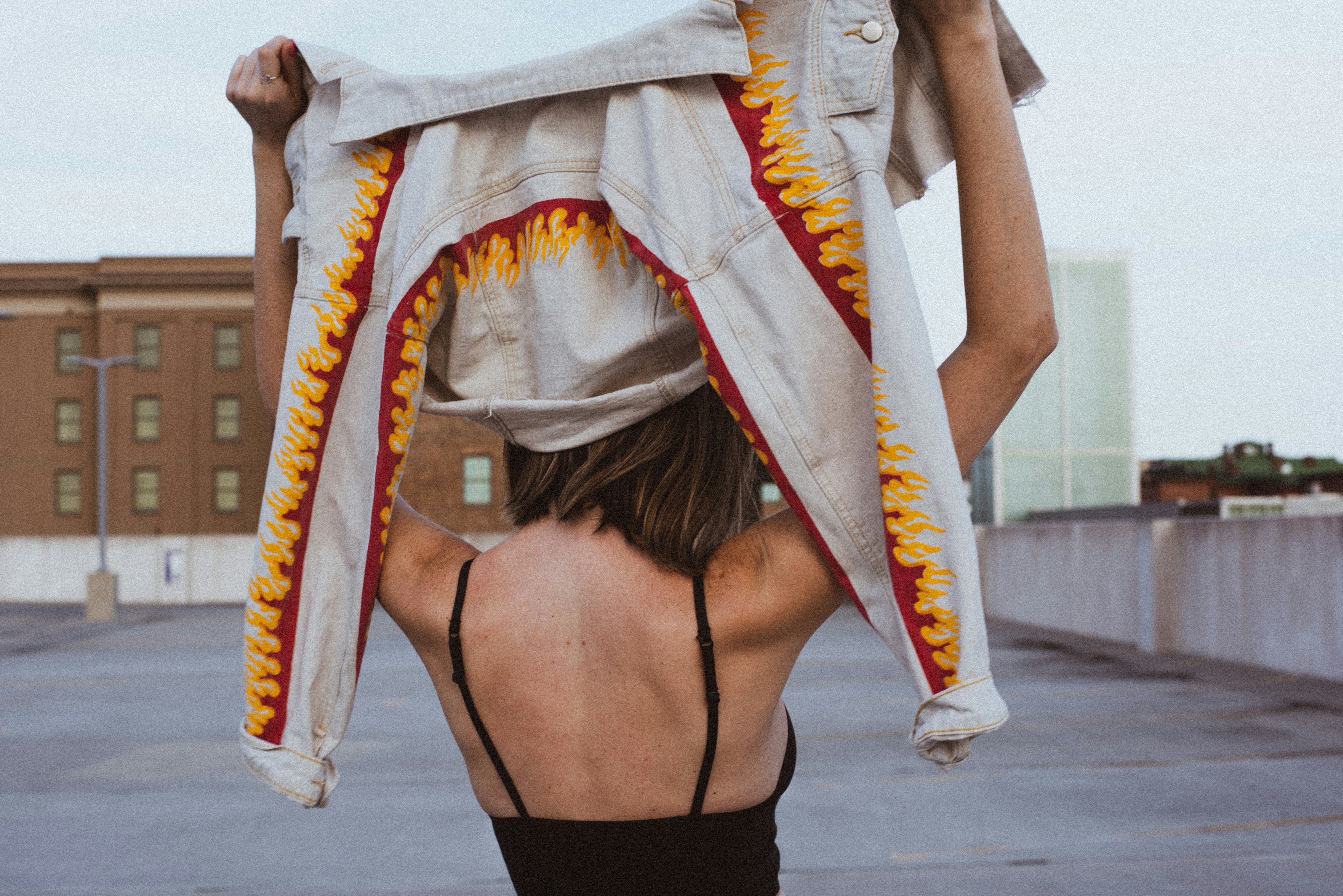 Raising the Rooftop Banner: A Figure Unfolding Toward the Horizon
