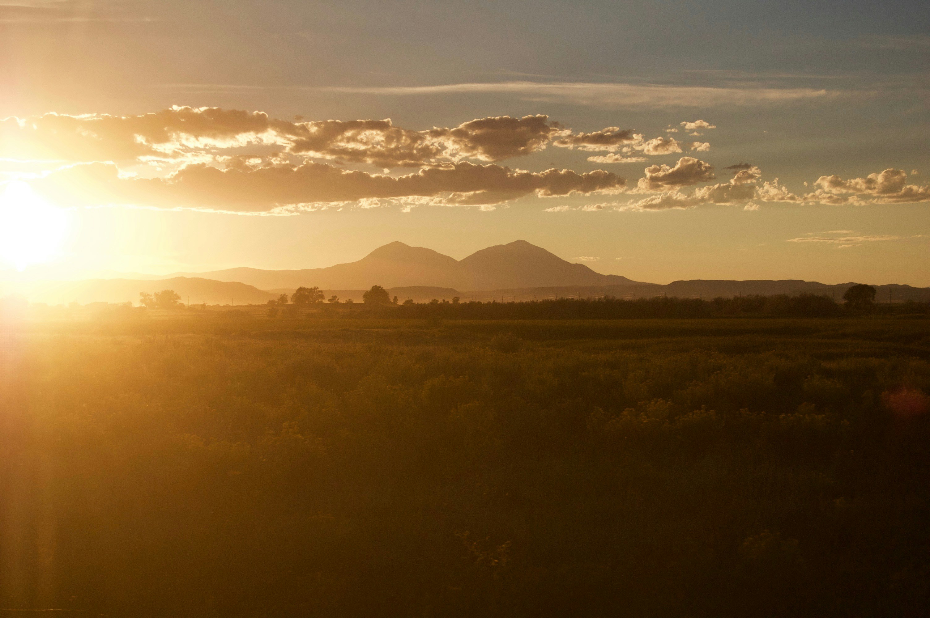 Sun-Glazed Horizon: Distant Hills Under a Low Sun