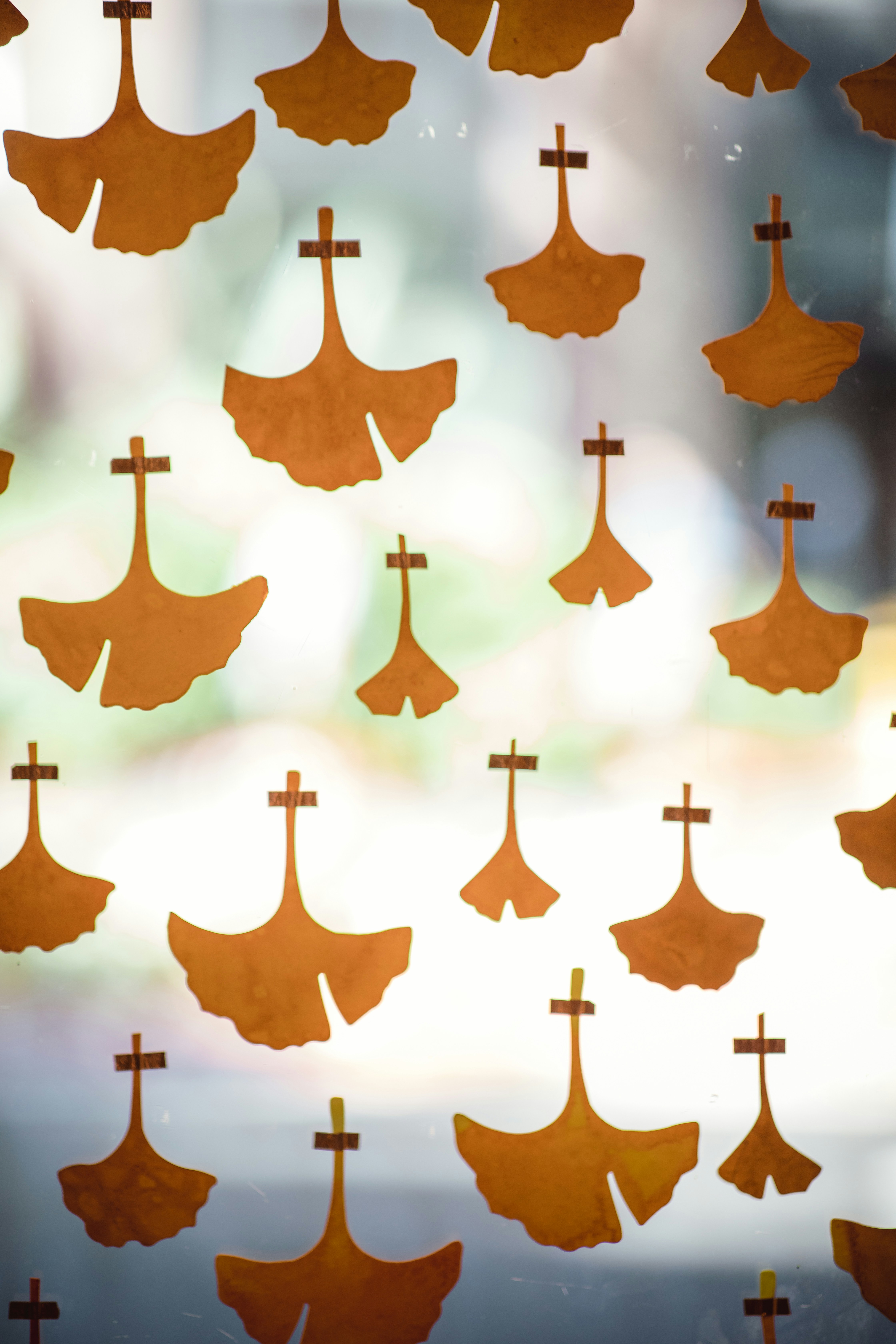Copper Ginkgo Cutouts: Backlit Repetition on Translucent Glass