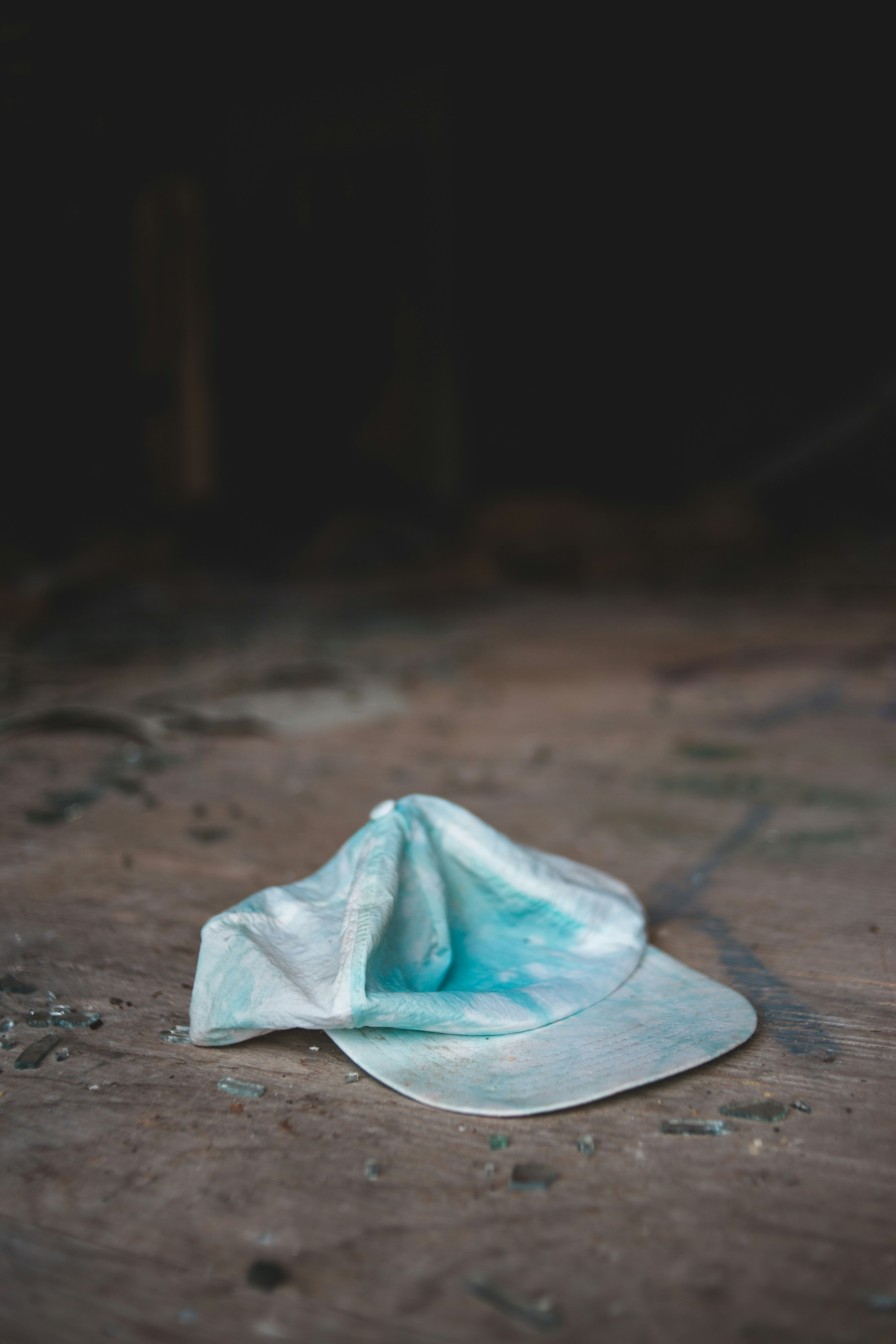 Blue Mask on a Weathered Floor: Quiet Decay in a Dim Room