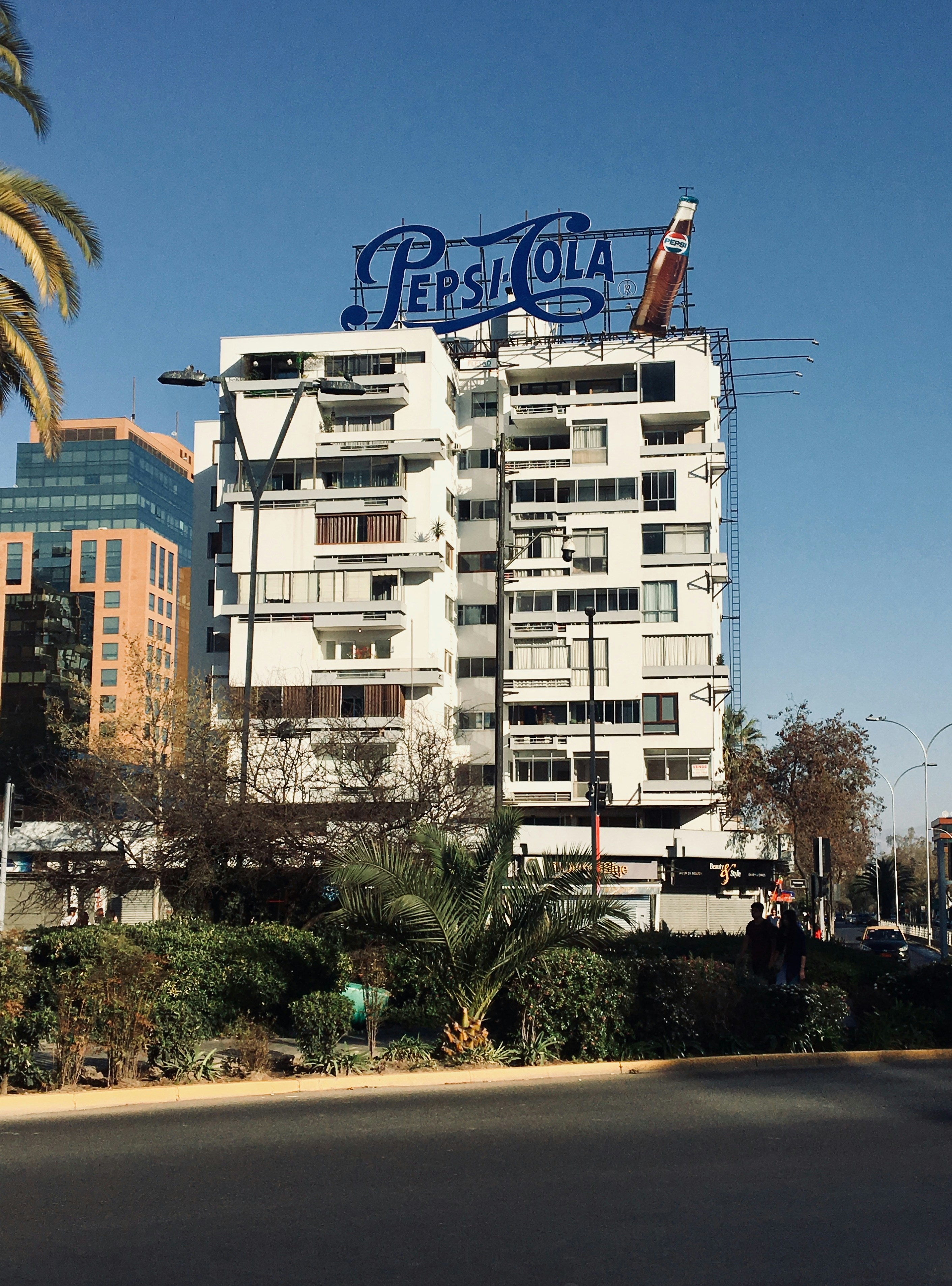 Pepsi-Cola Sign Crowns a Sunlit White Urban Block