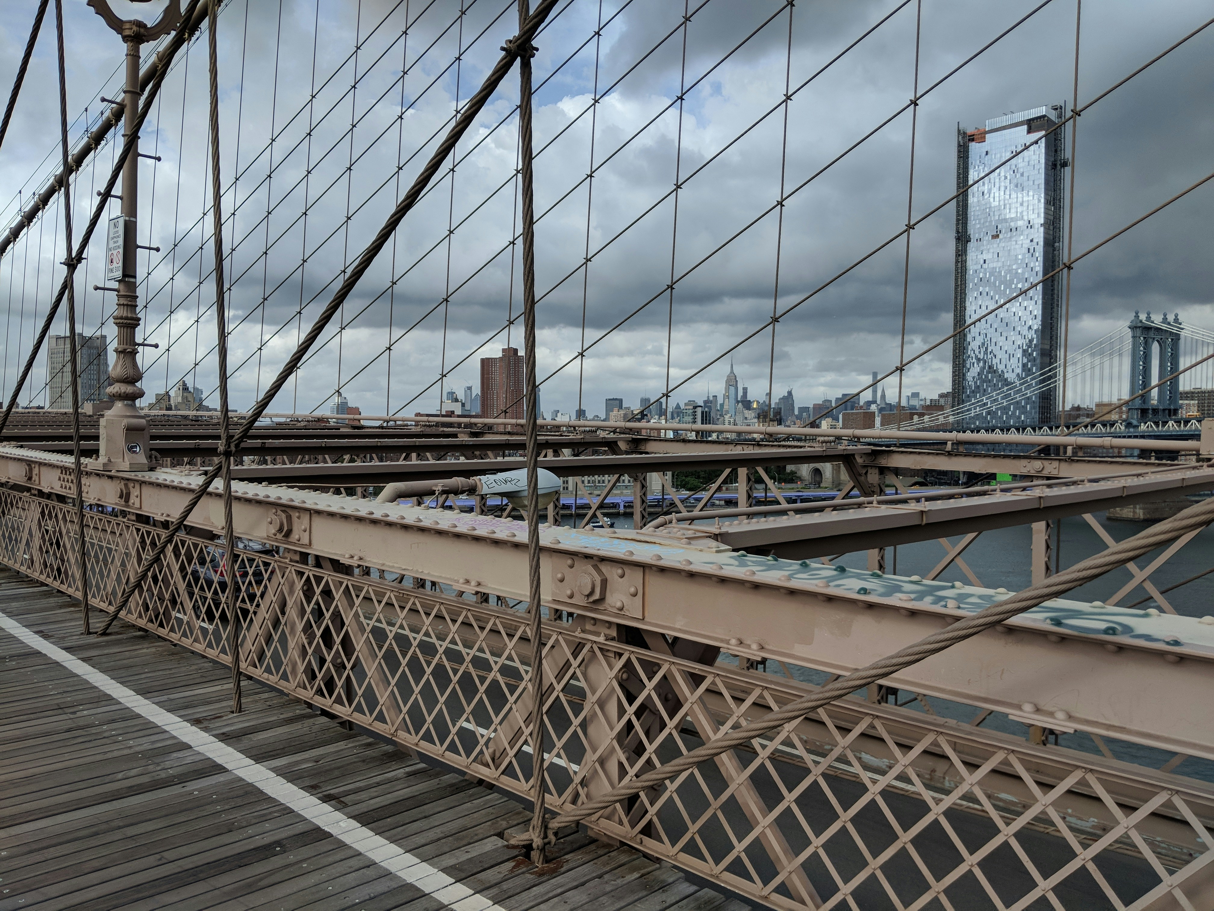 Brooklyn Bridge Walk: Cables Leading to a Cloudy Skyline