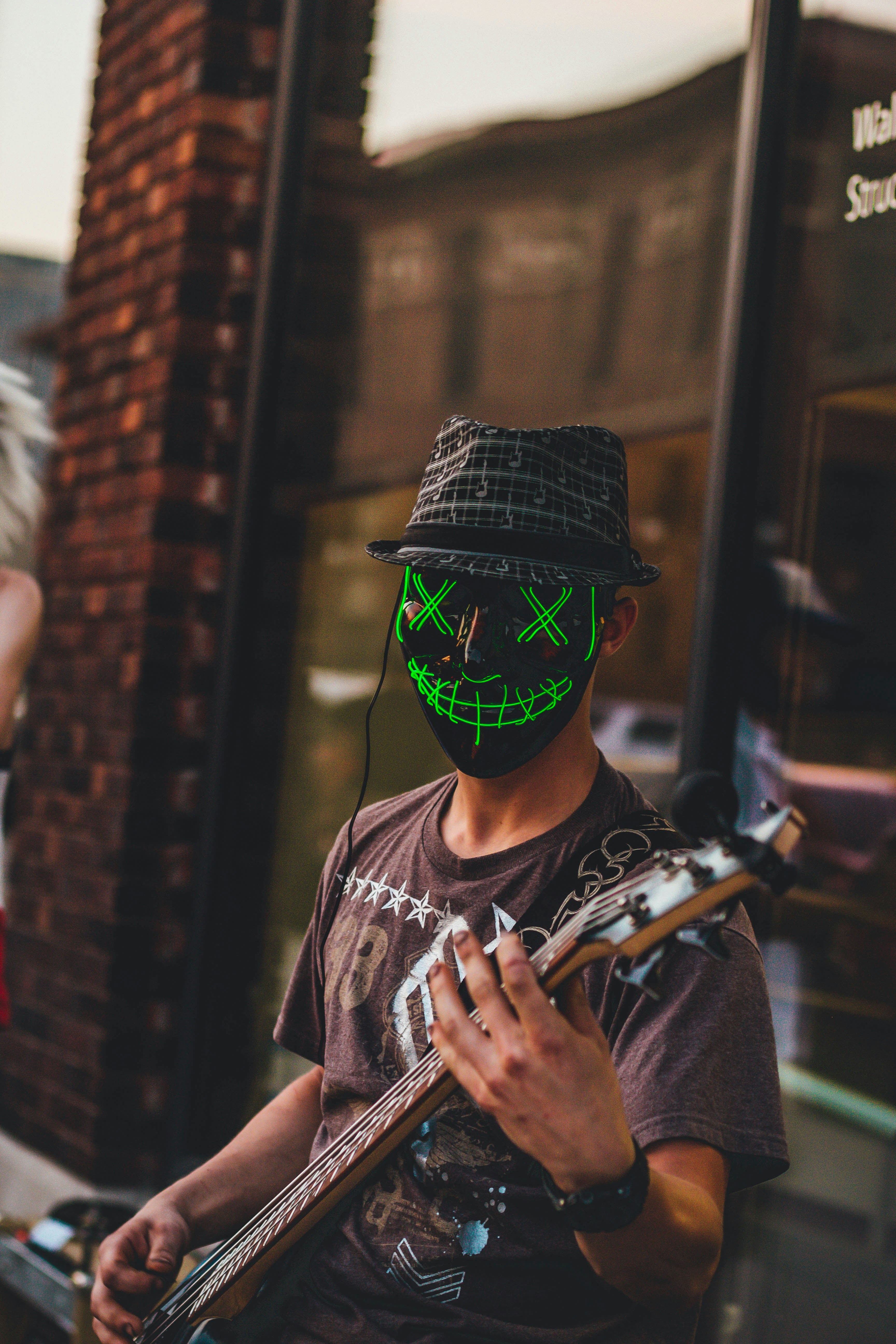 Neon-Grin Guitarist in a Brick-and-Glass City Scene