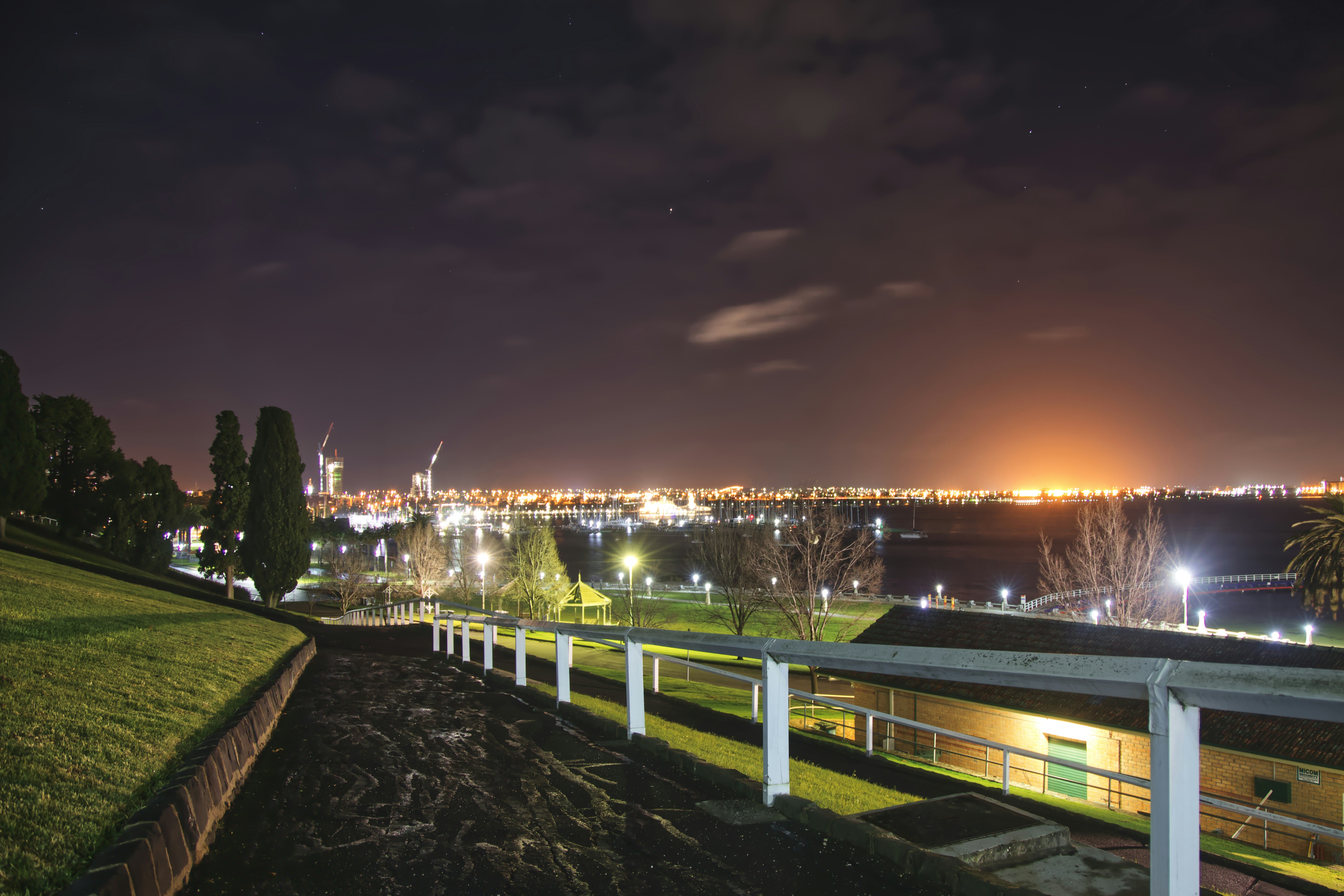 Riverside Nightscape: Warm City Glow Behind Painted Rails