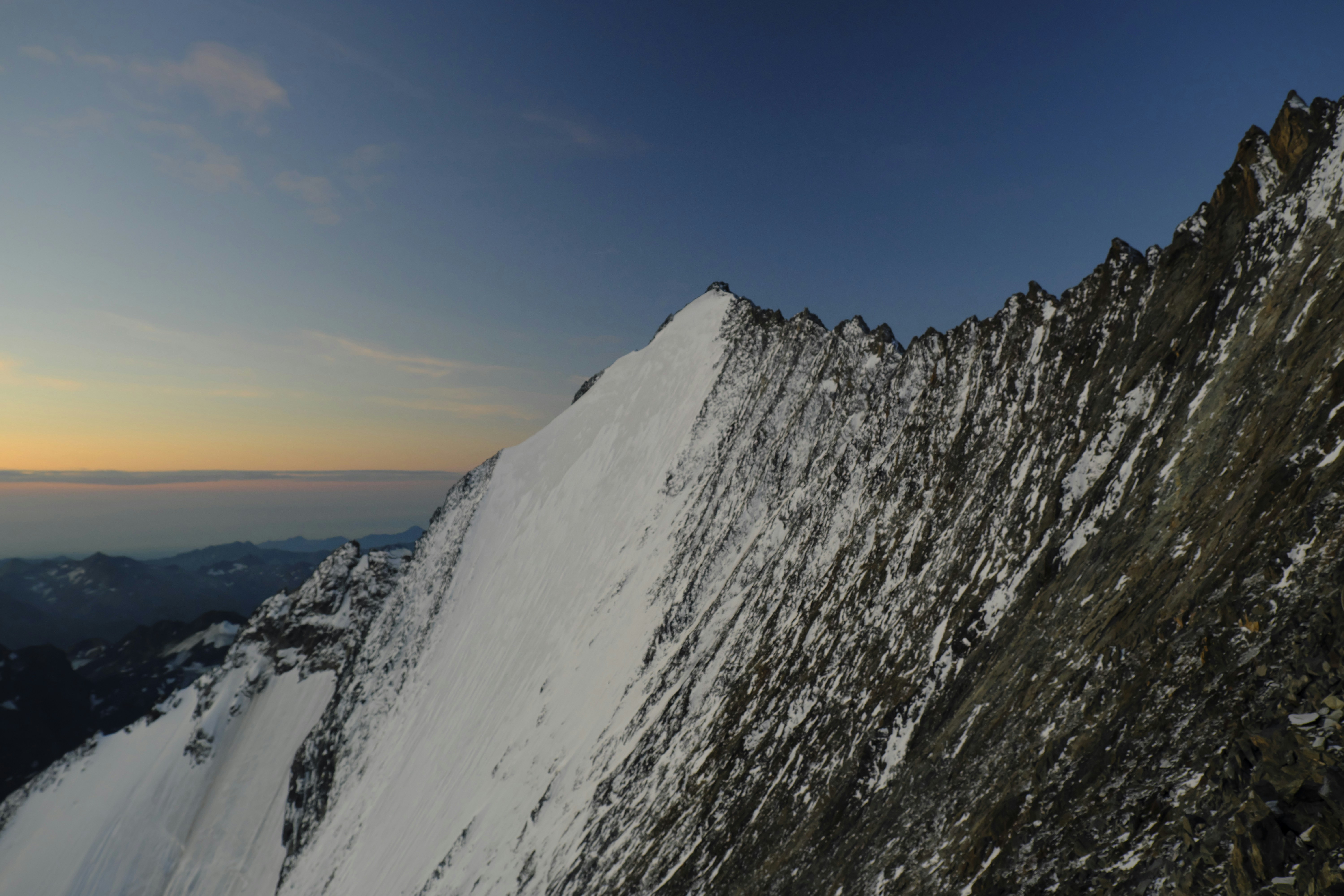 Edge of Dawn: Snow-Crowned Ridge at Far Horizon