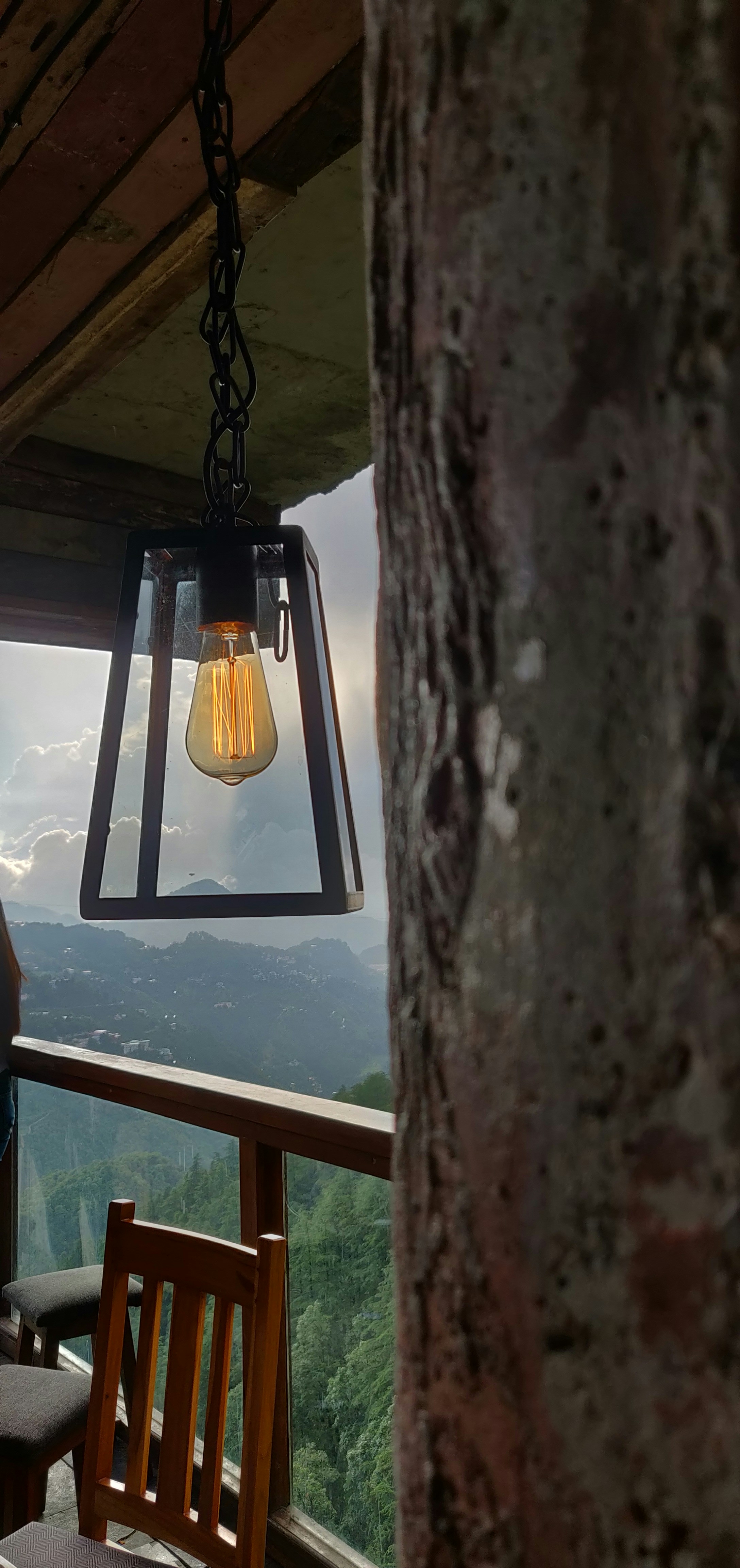 Lantern in the Wind: Warm Glow Over a Misty Mountain Balcony