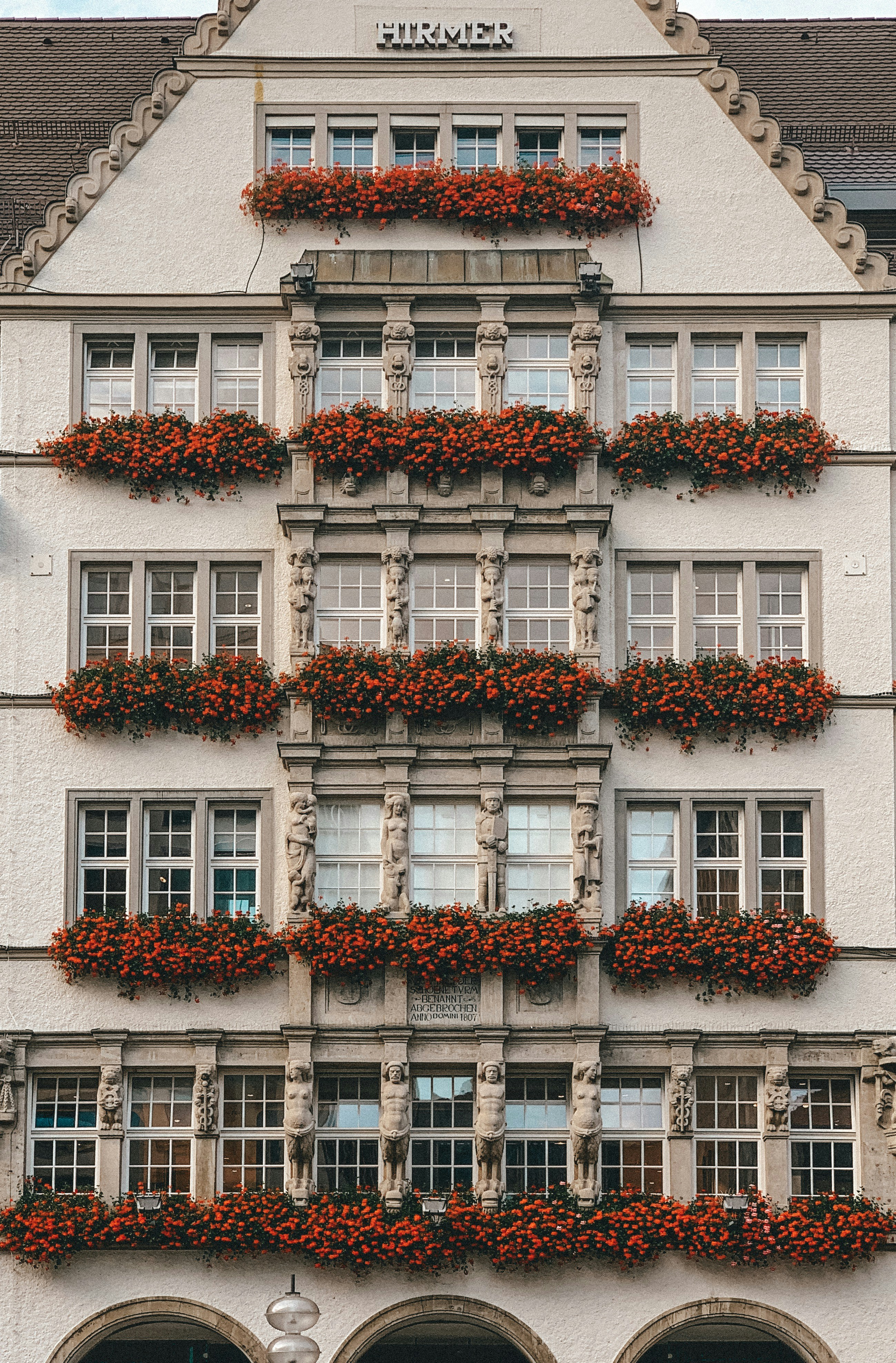 Symmetrical Red Blooms Crown a Historic European Façade