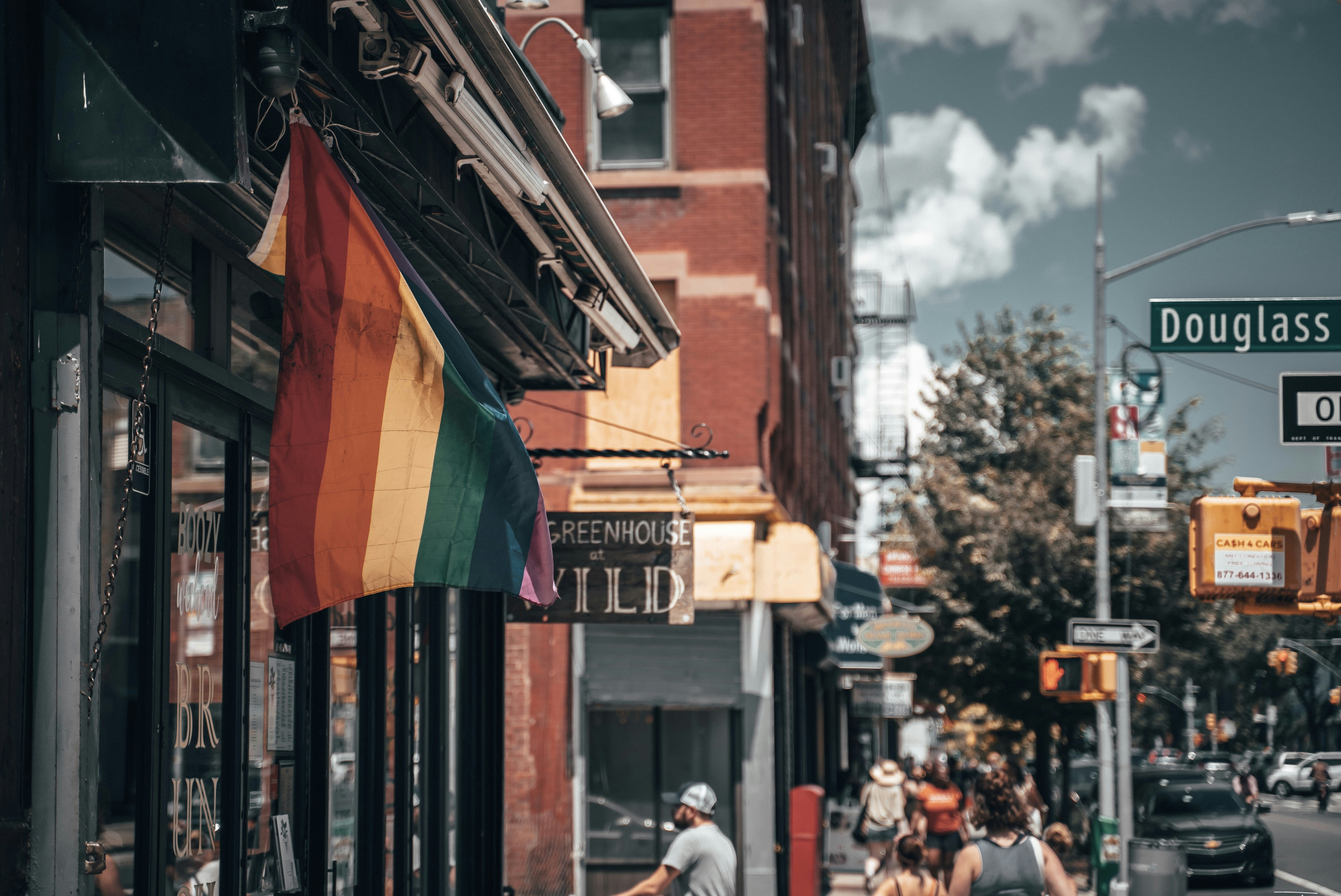 Rainbow Flag and City Pulse on a Sunlit Street