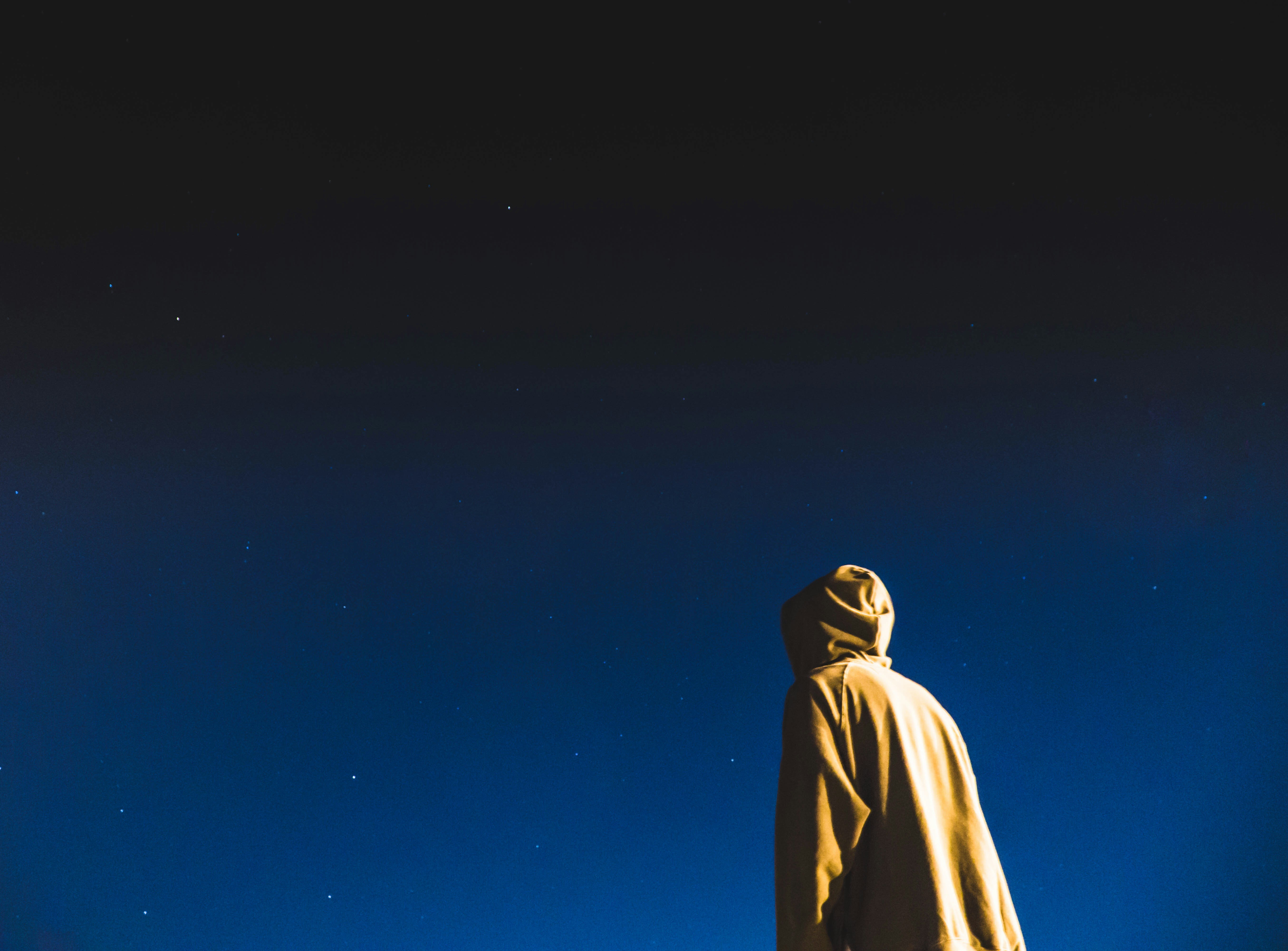 A Hooded Figure Under a Quiet Night Sky